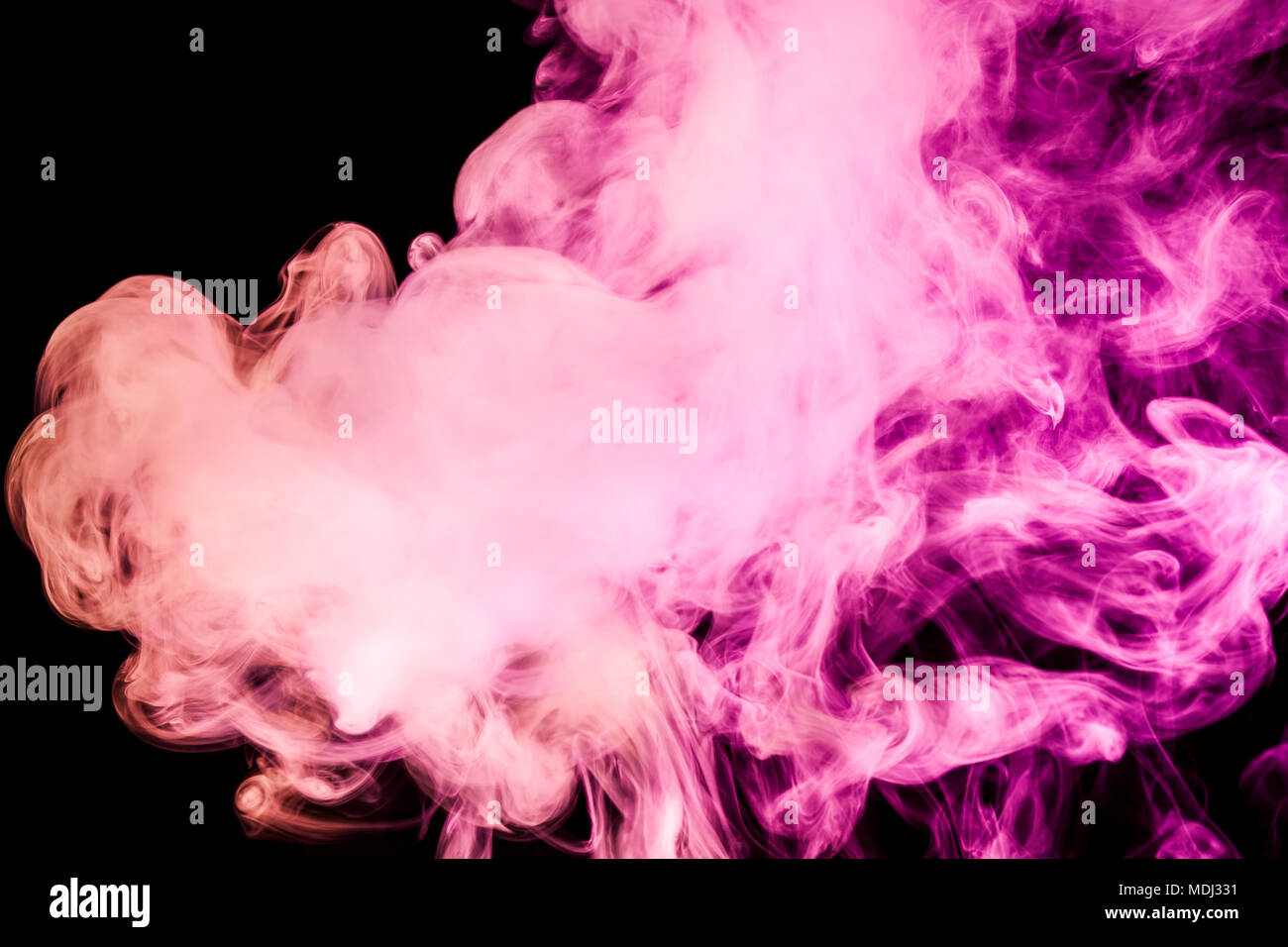 Thick colorful pink and red smoke on a black isolated background ...