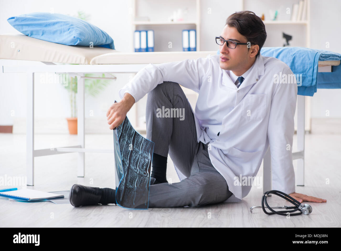 Doctor sitting on the floor in hospital Stock Photo - Alamy