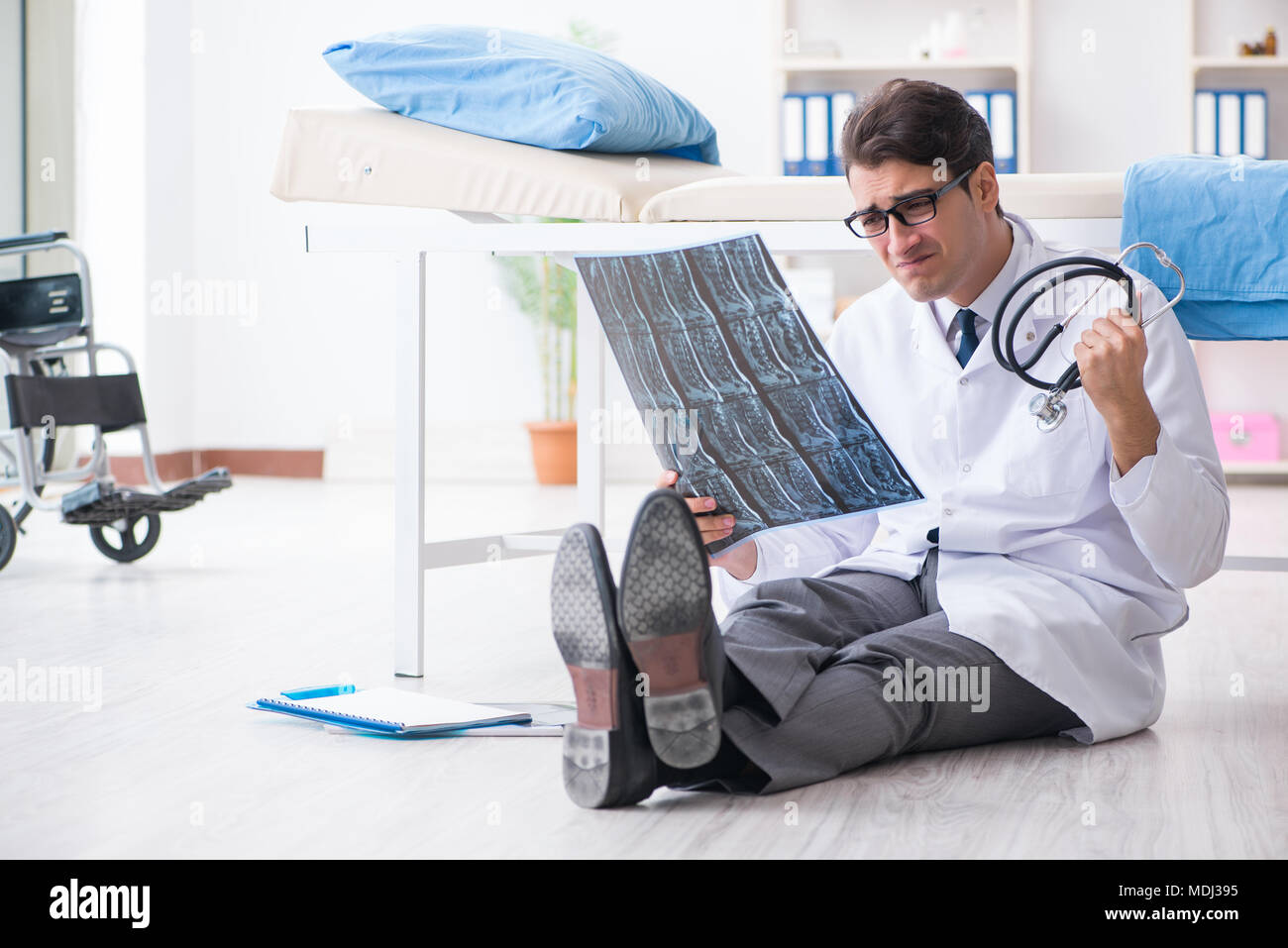 Doctor sitting on the floor in hospital Stock Photo - Alamy