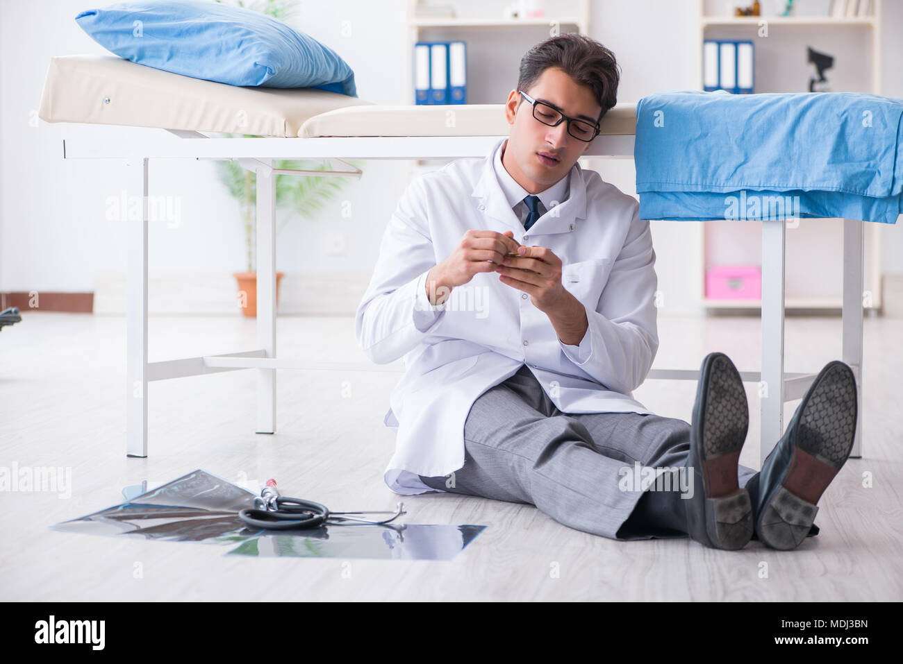 Doctor sitting on the floor in hospital Stock Photo - Alamy