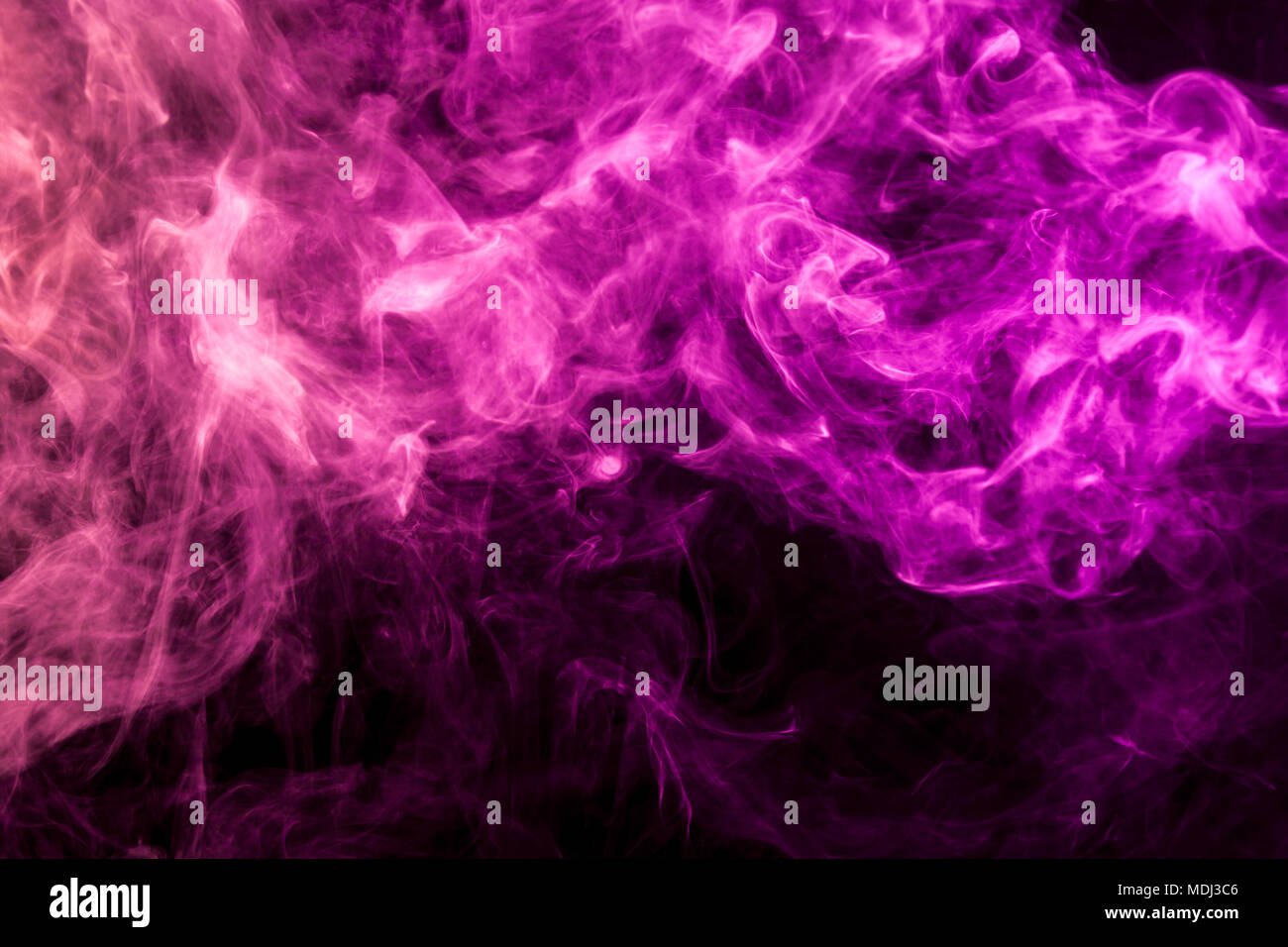 Dense multicolored pink and red smoke on a black isolated background ...