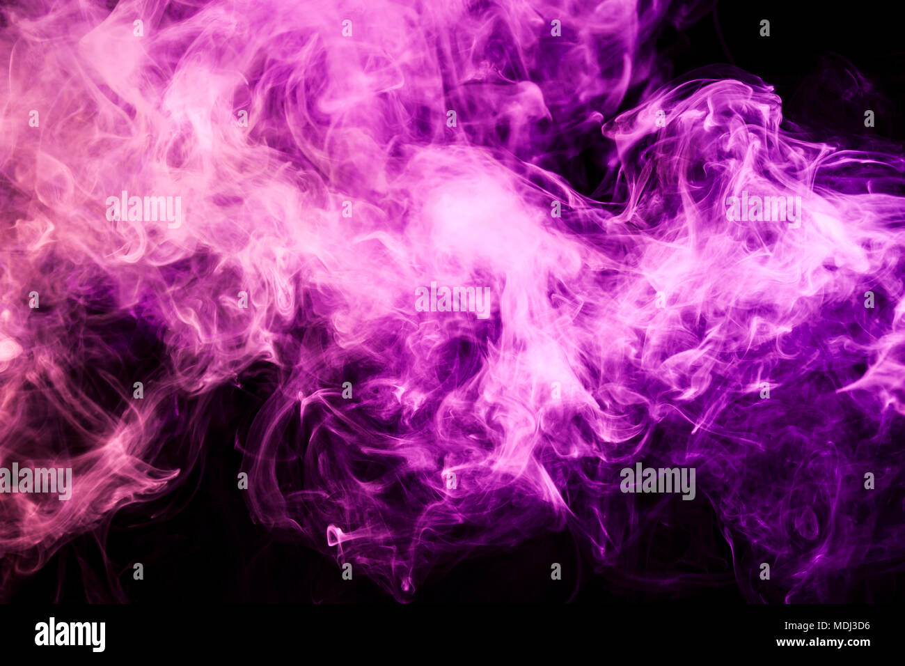 Dense multicolored pink and red smoke on a black isolated background ...