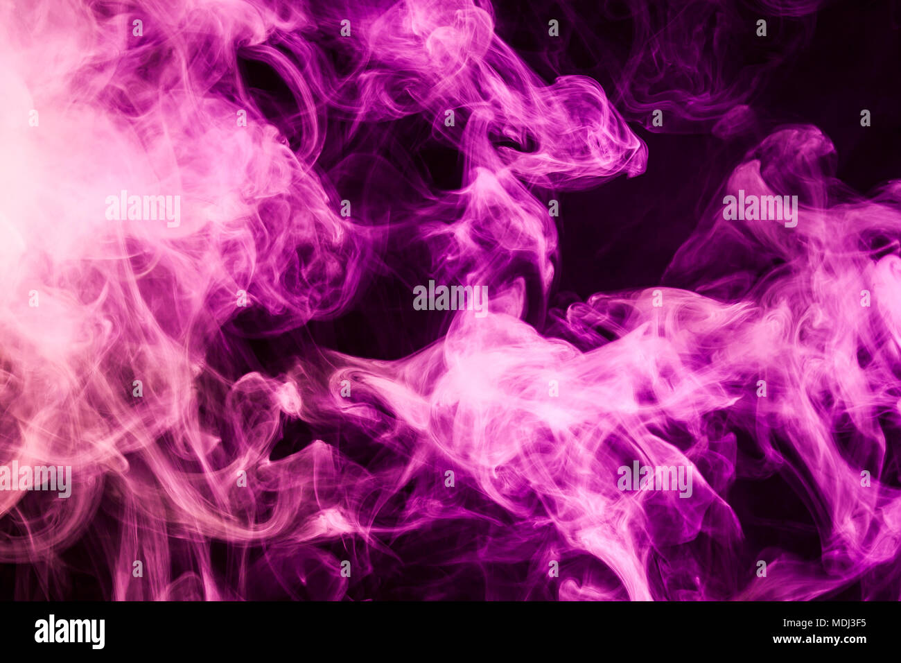 Dense multicolored pink and red smoke on a black isolated background ...
