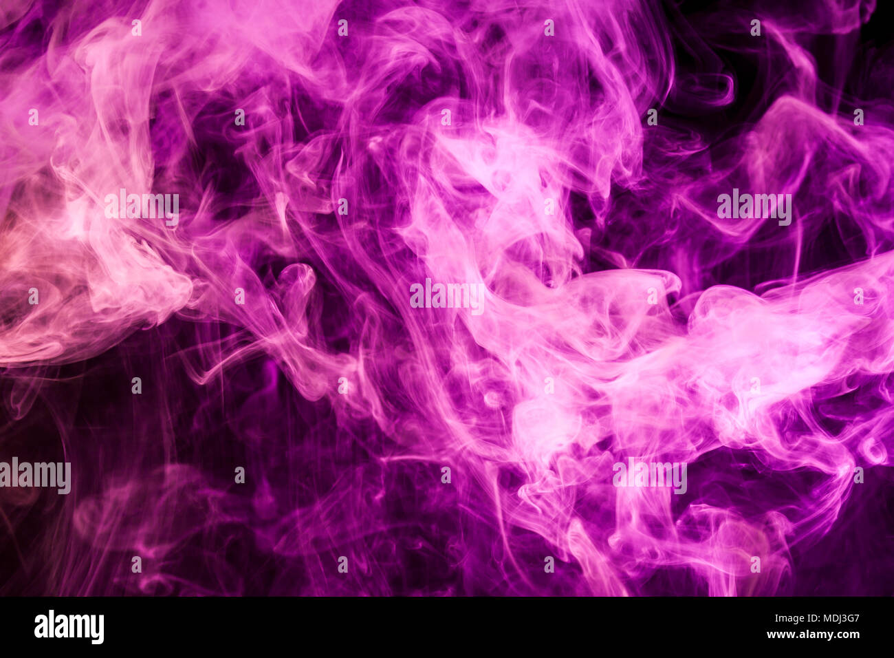 Dense multicolored pink and red smoke on a black isolated background ...