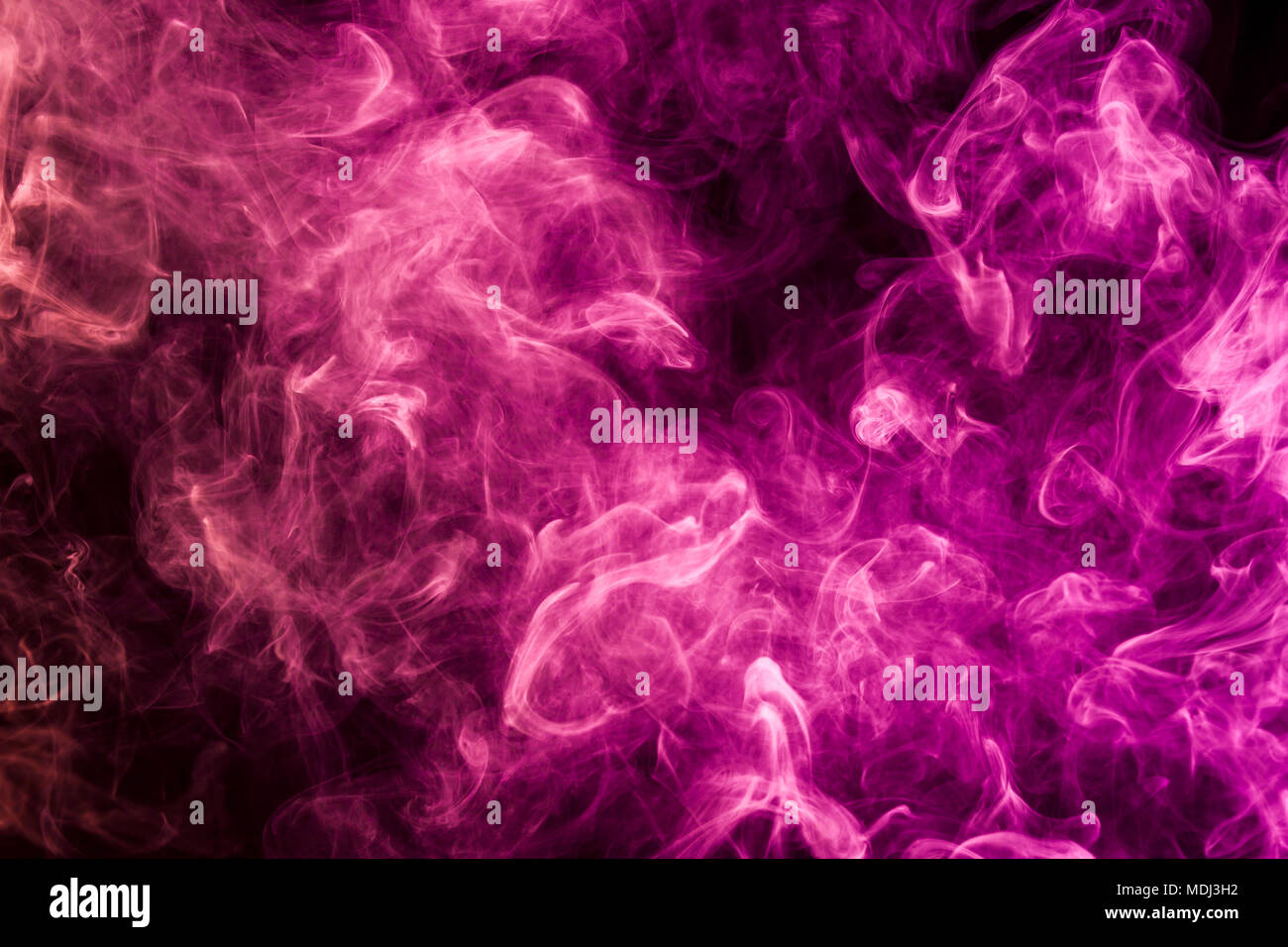 Dense multicolored pink and red smoke on a black isolated background ...