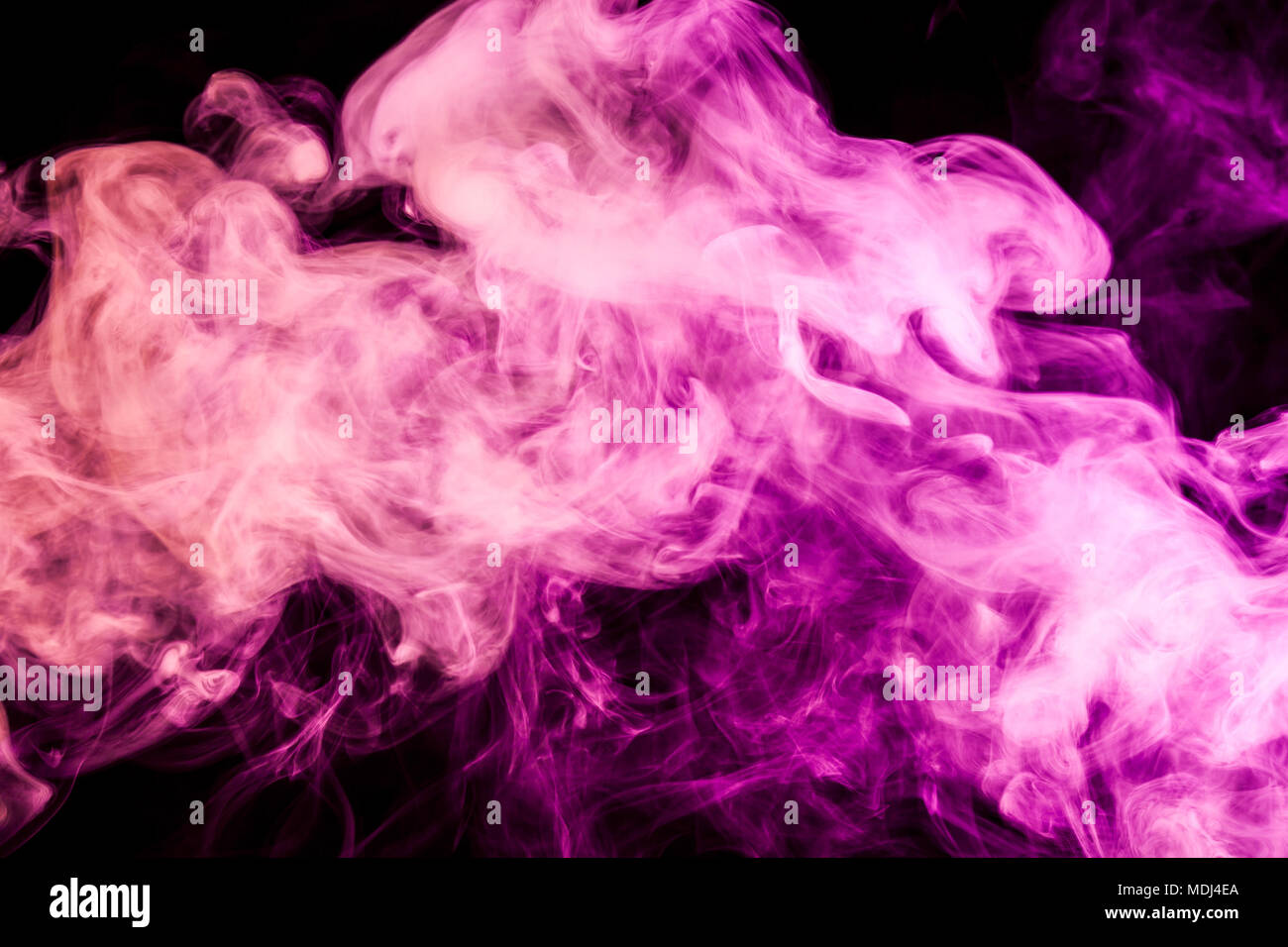 Dense multicolored pink and red smoke on a black isolated background ...