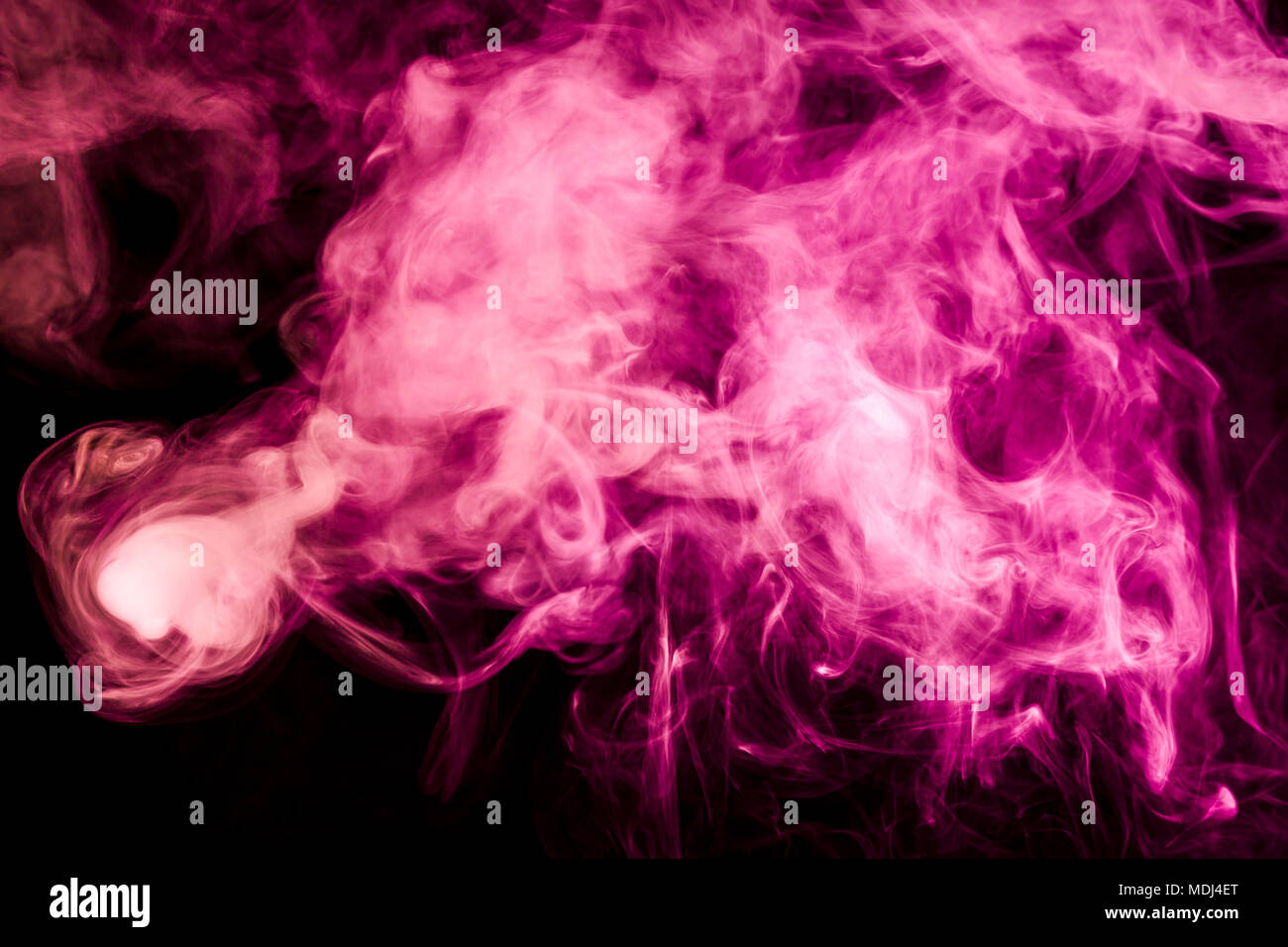 Dense multicolored pink and red smoke on a black isolated background ...