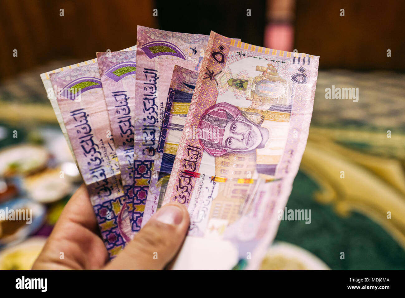 Paying with local Rial banknotes in Oman Stock Photo - Alamy