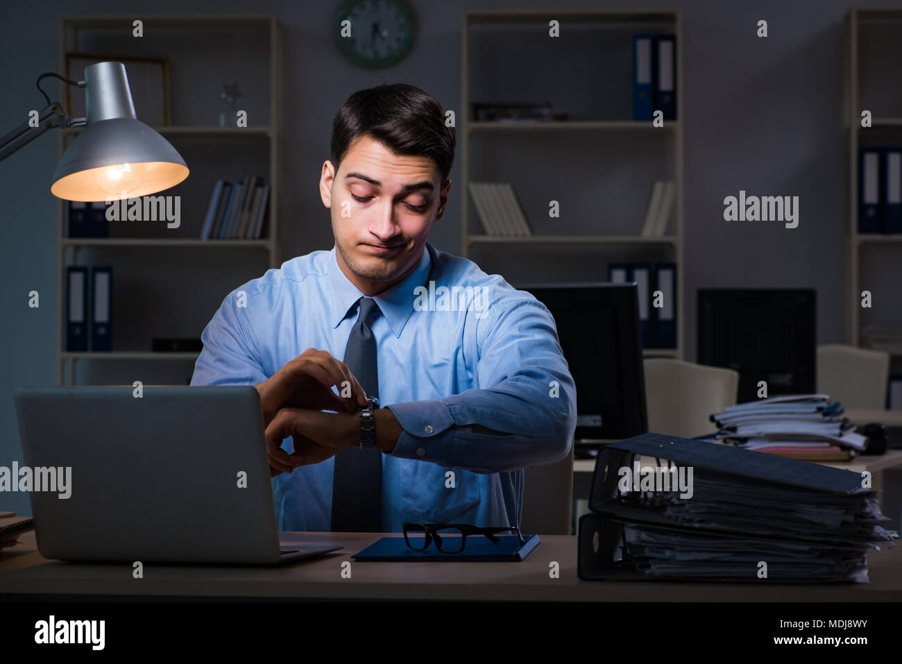 Employee working late at night at important report Stock Photo - Alamy