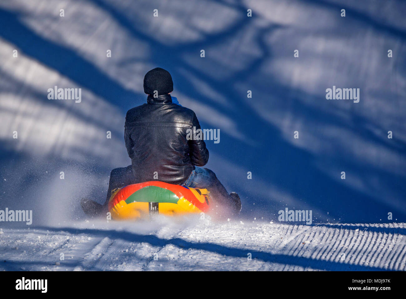 Man with daughter sledding down a snowy hill Stock Photo - Alamy