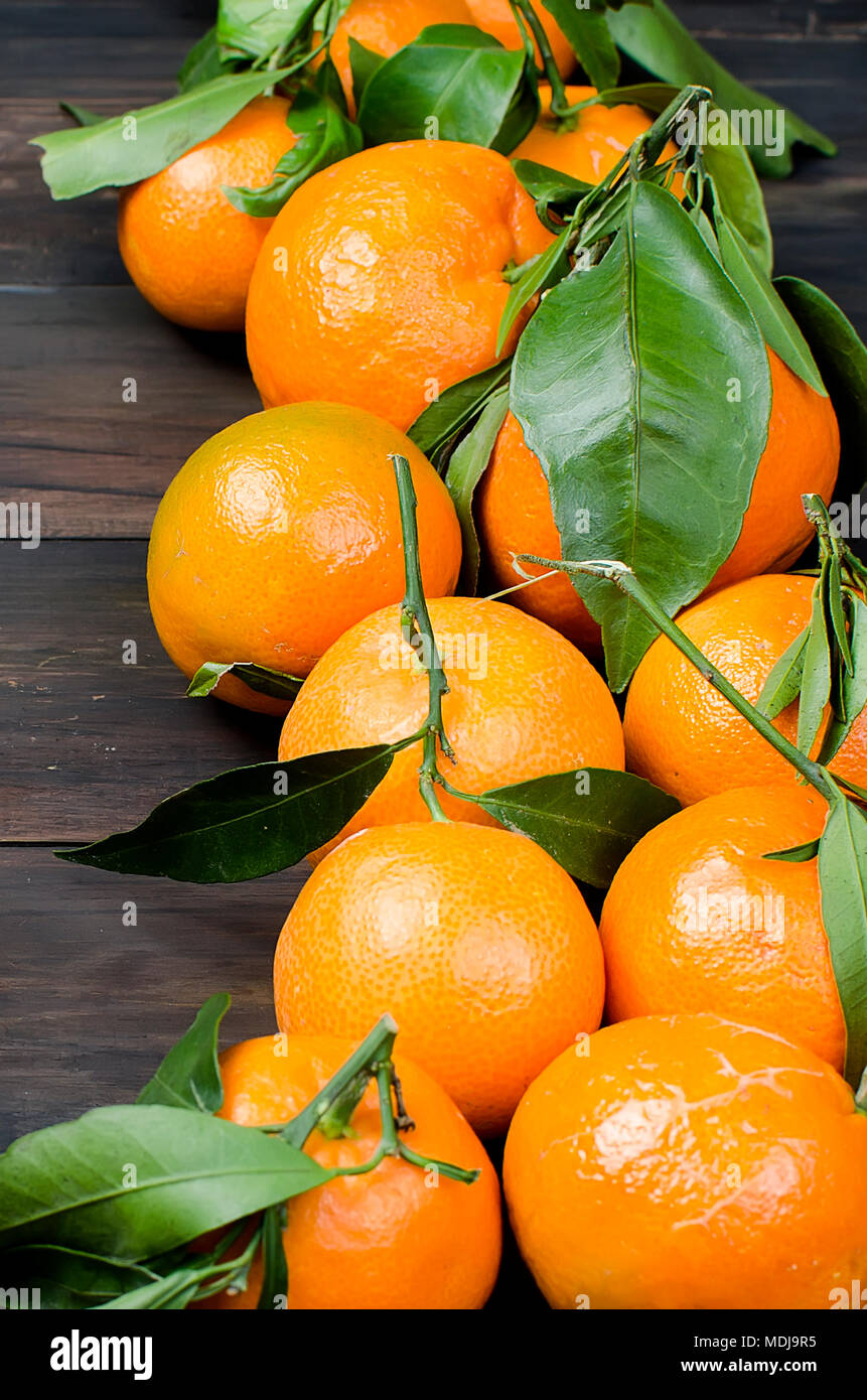Fresh raw organic Tangerines clementine with green leaves on dark old ...