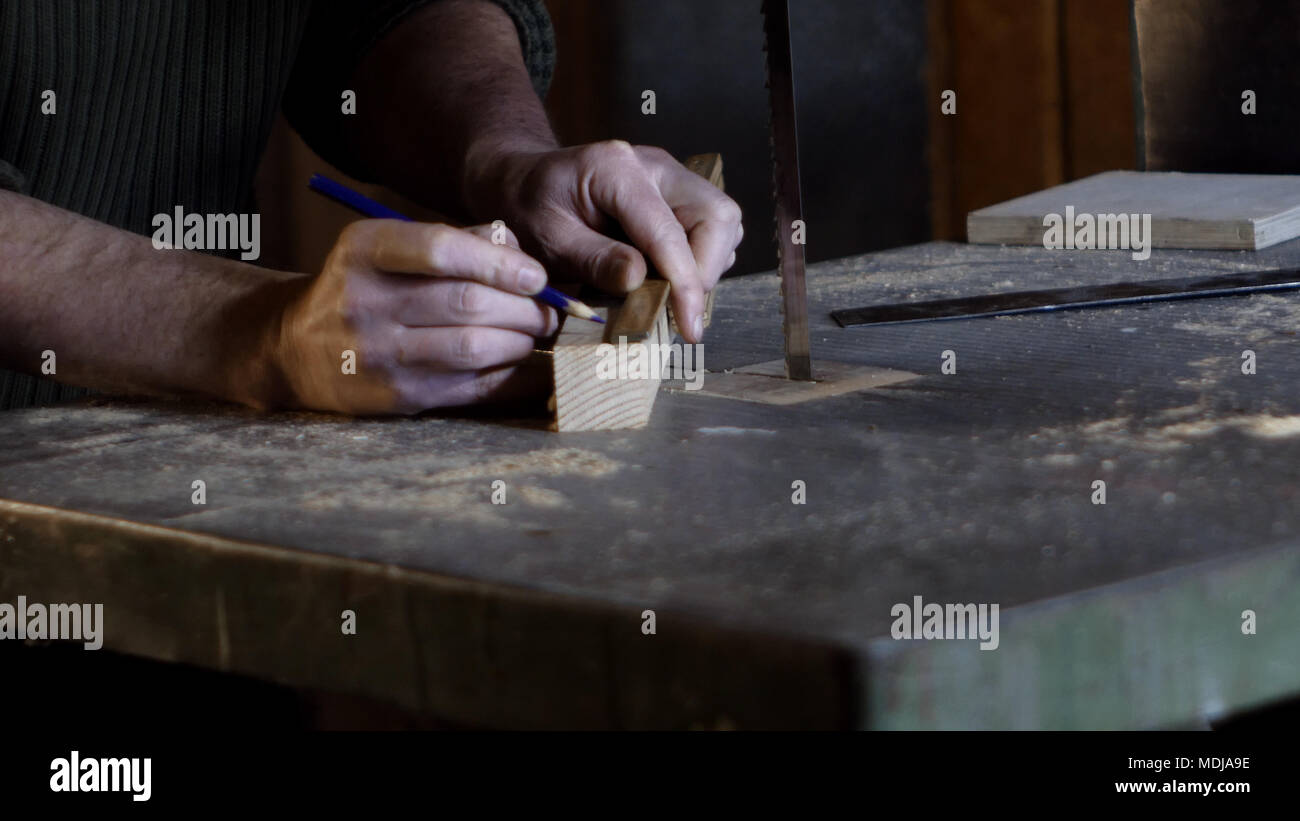 Carpenter measures and marks cutting line using a carpenter's ruler ...