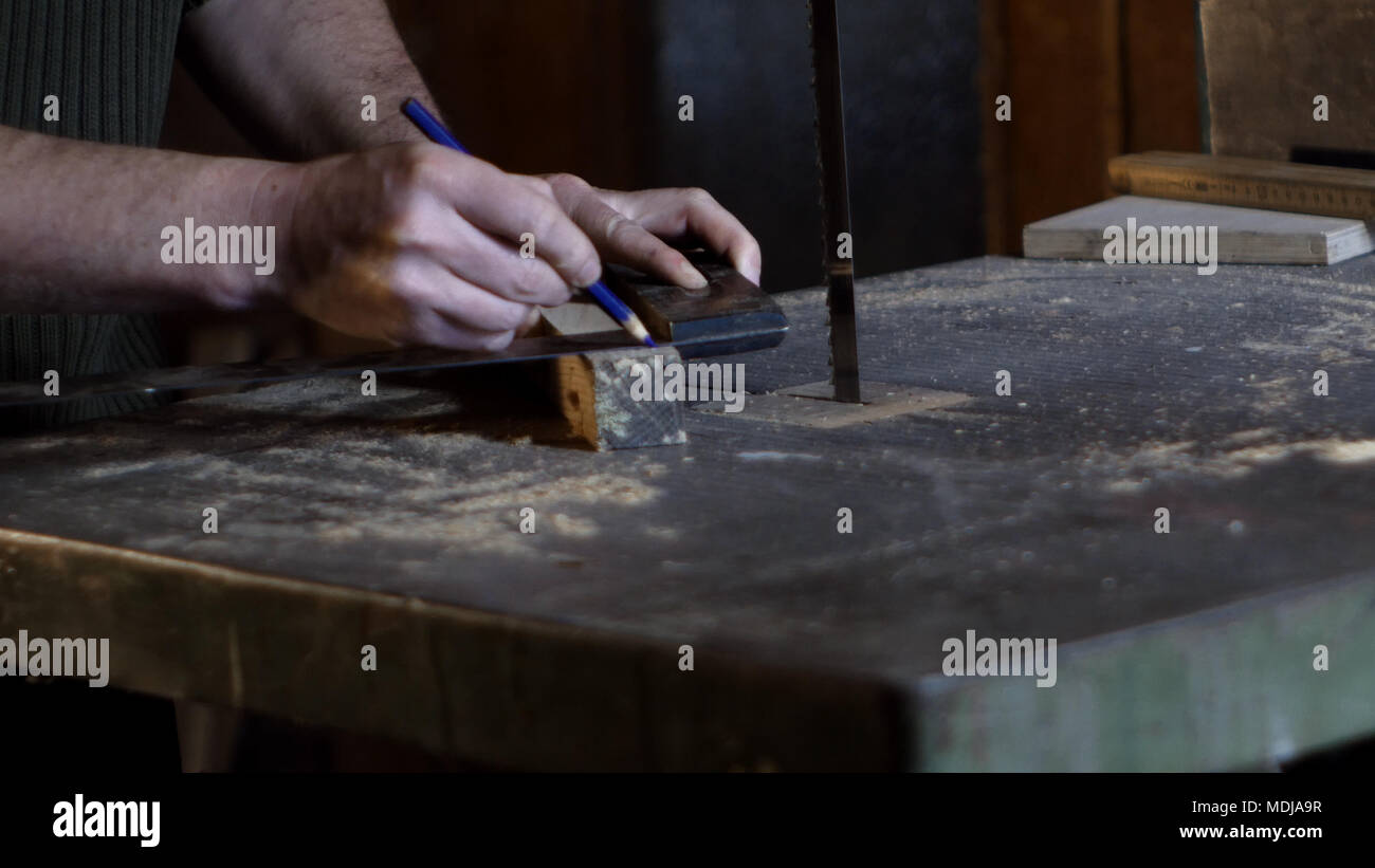 Carpenter measures and marks cutting line using a carpenter's ruler ...