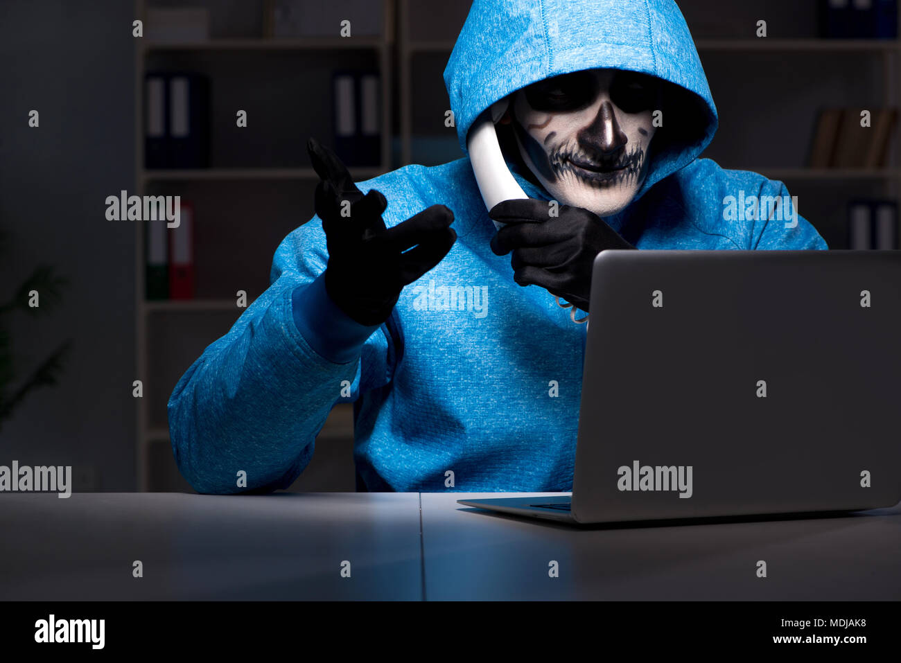 Scary hacker hacking security firewall late in office Stock Photo - Alamy