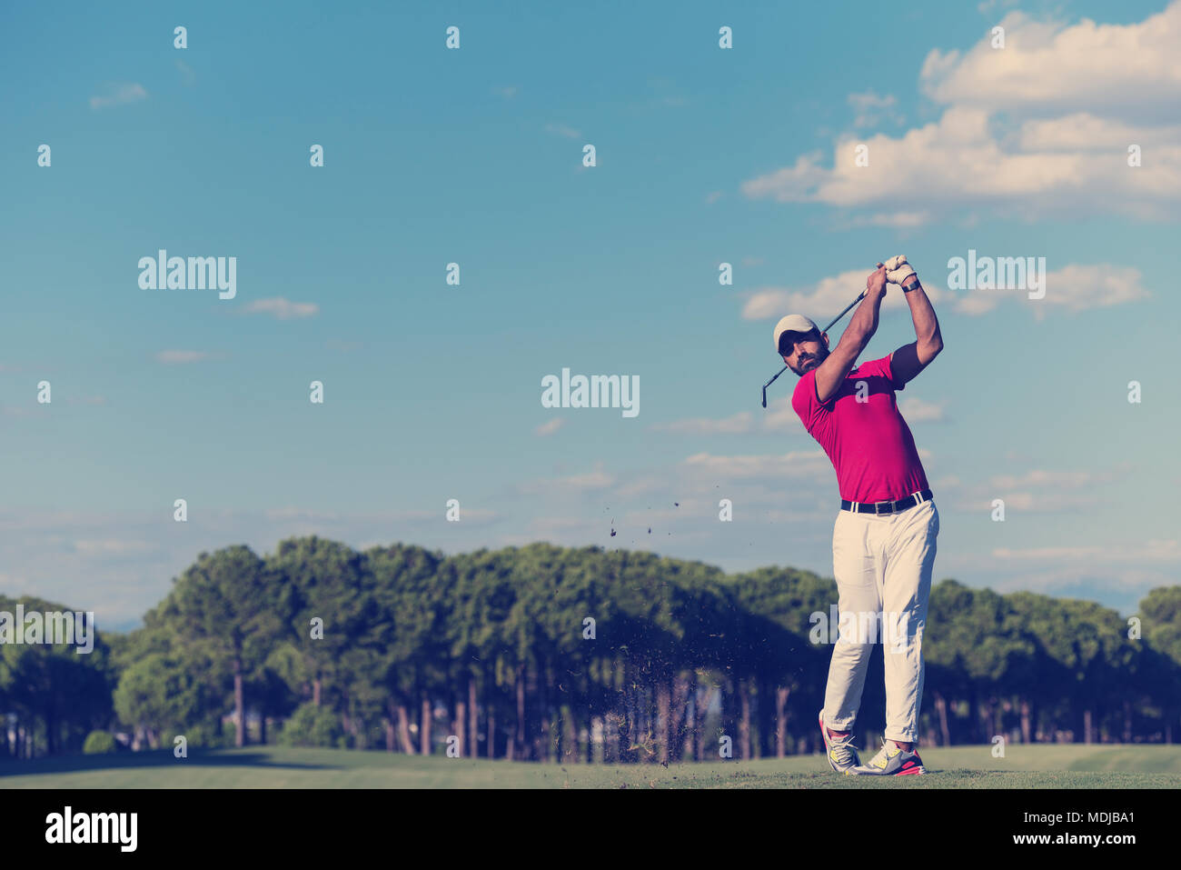 golf player hitting shot with driver on course at beautiful sunny day ...