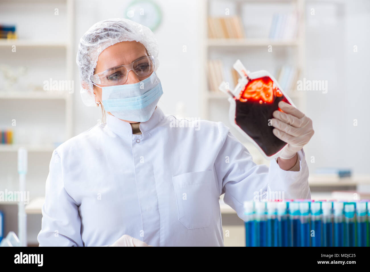 Woman doctor checking blood samples in lab Stock Photo - Alamy