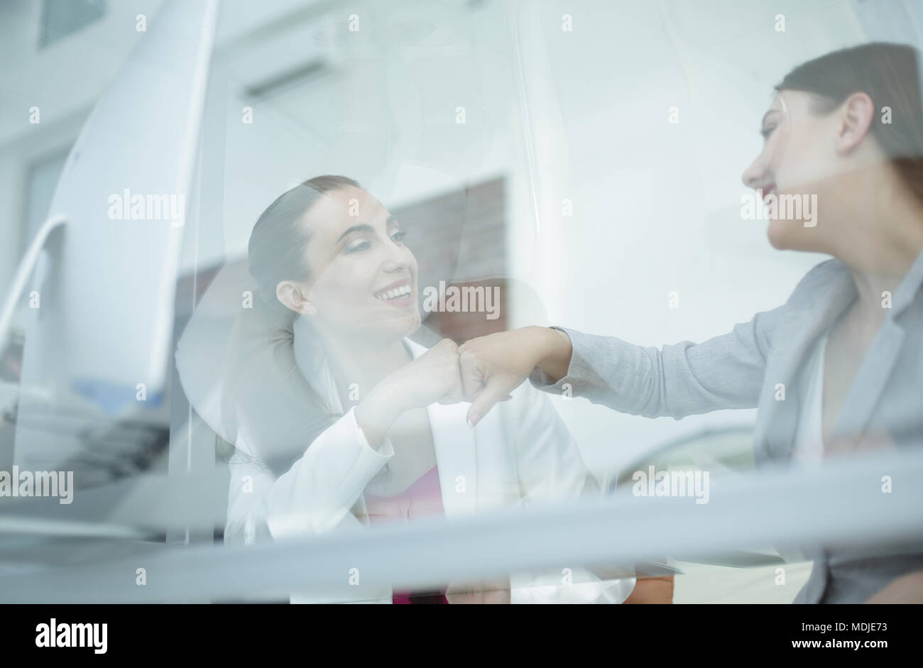behind the glass.colleagues celebrate their success Stock Photo - Alamy