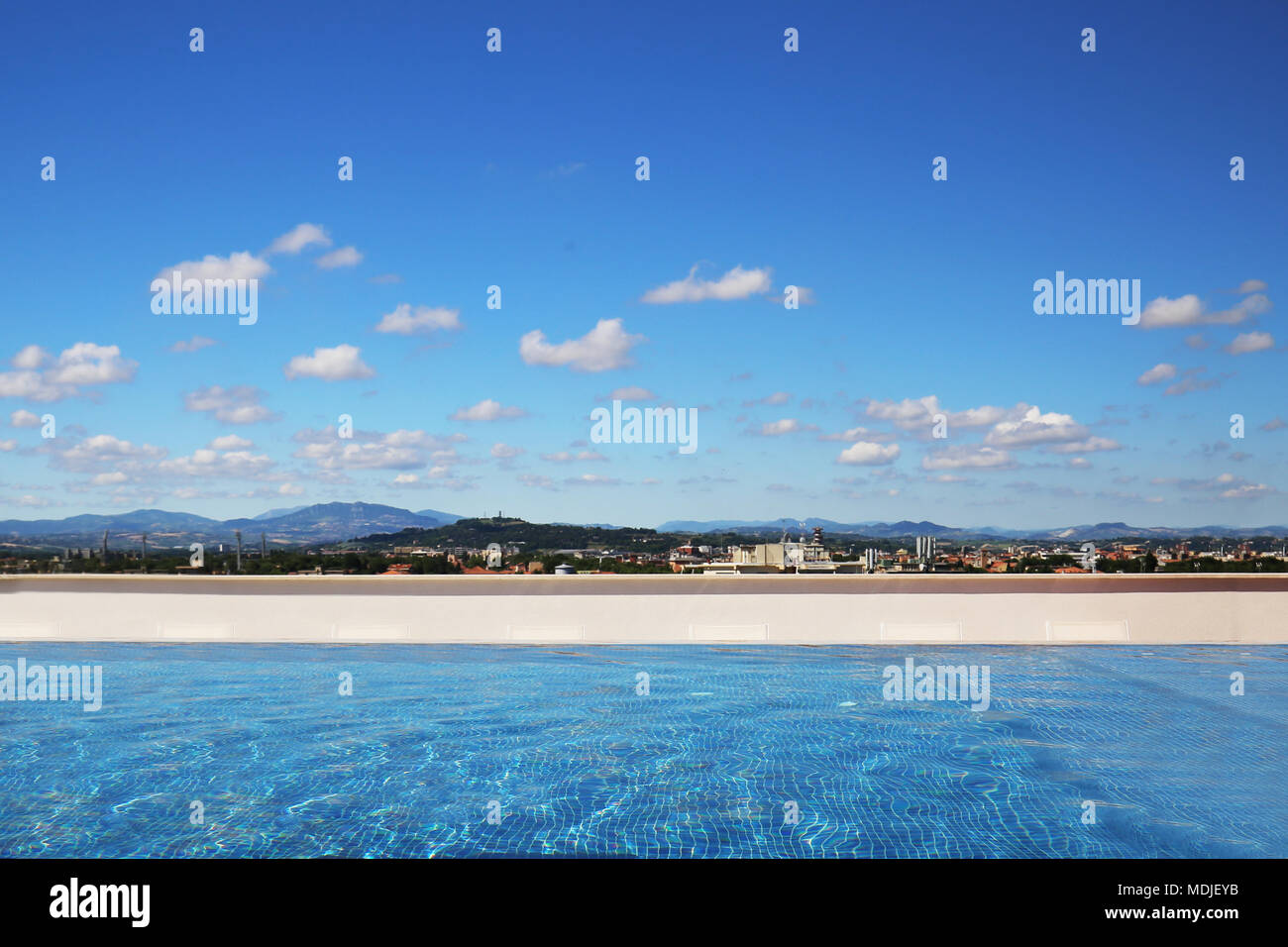 Luxury swimming pool on rooftop. Blue sky with clouds and mountain ...