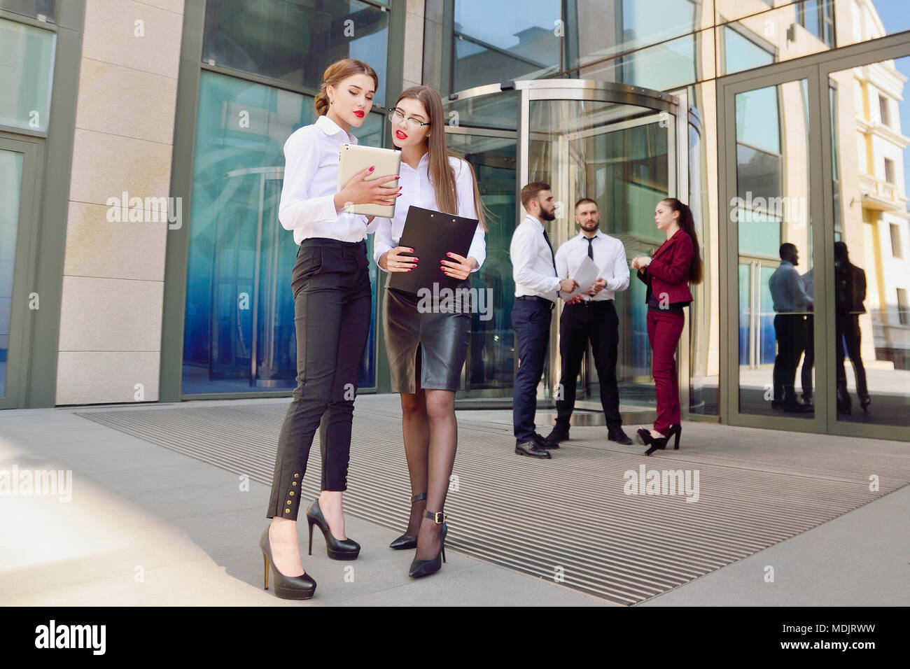 Business lady. Office staff. Two young girls with electronic tablets ...