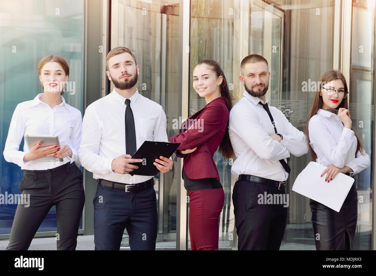 Command. Young office workers on the background of a multi-storey glass ...