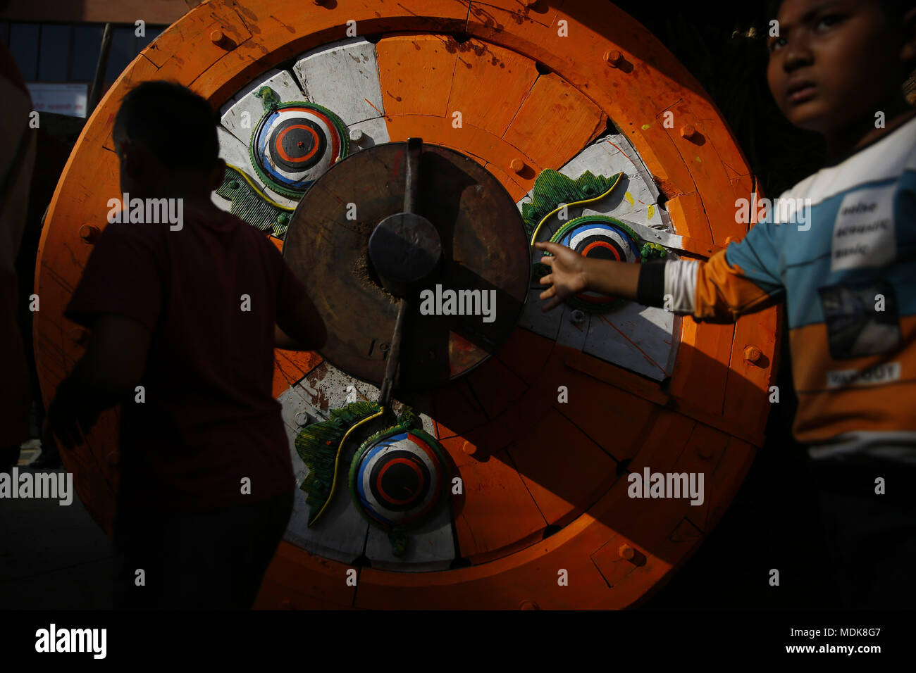 Lalitpur, Nepal. 20th Apr, 2018. Boys offer prayers on the wheels of a ...