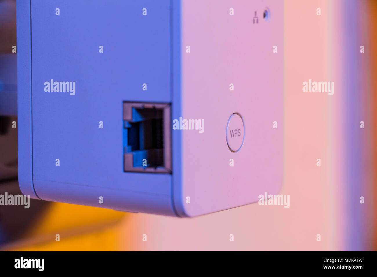 Closeup on WiFi repeater WPS button and ethernet socket. The device is ...