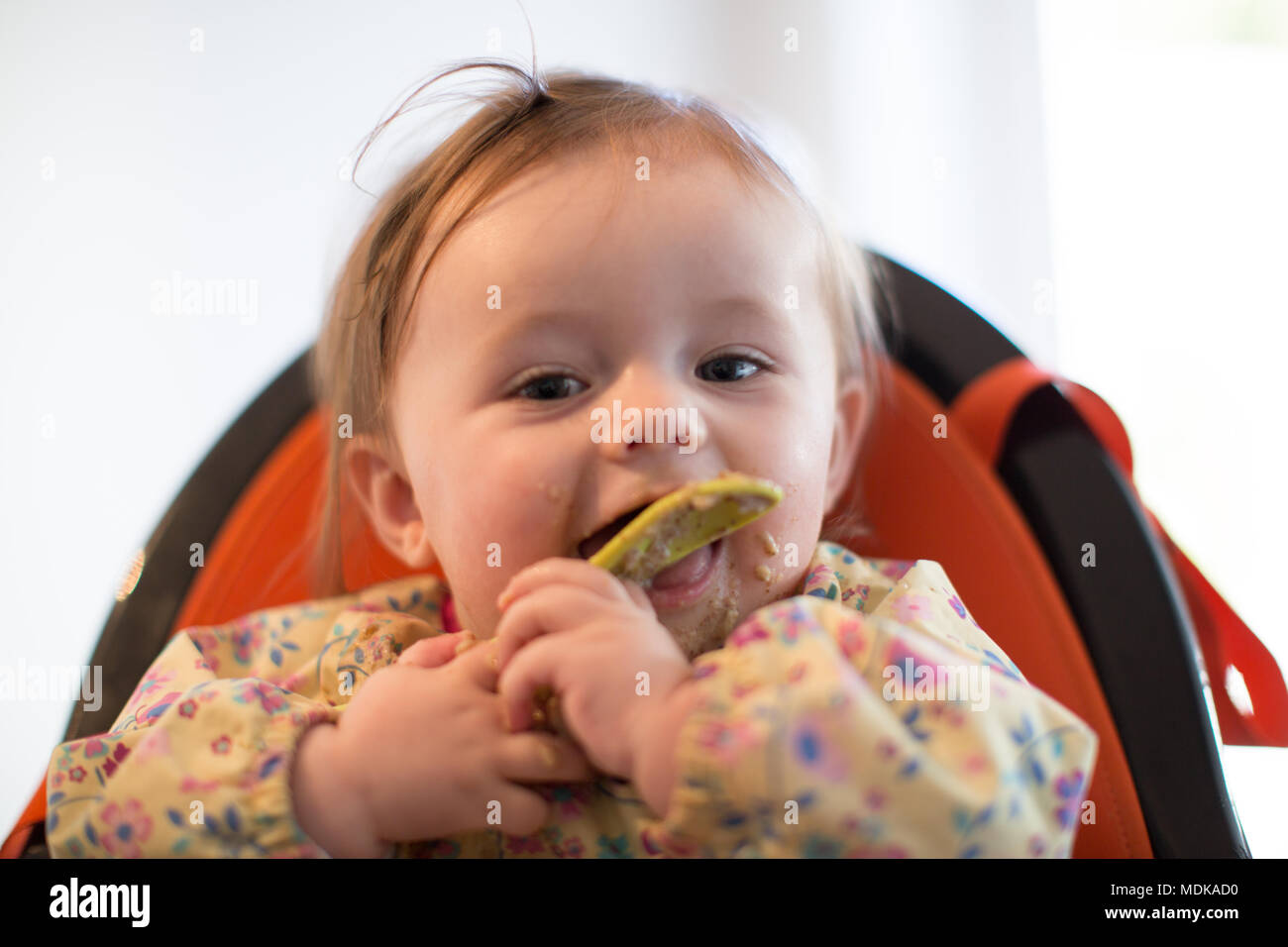 Baby feeding herself puree Stock Photo - Alamy