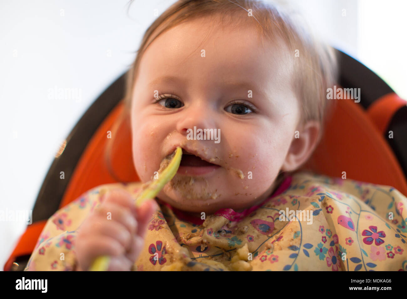 Baby feeding herself puree Stock Photo - Alamy