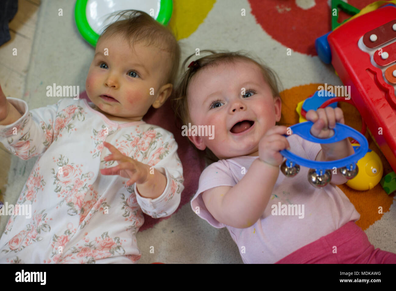 5 & 6 month old babies lying down interacting Stock Photo - Alamy