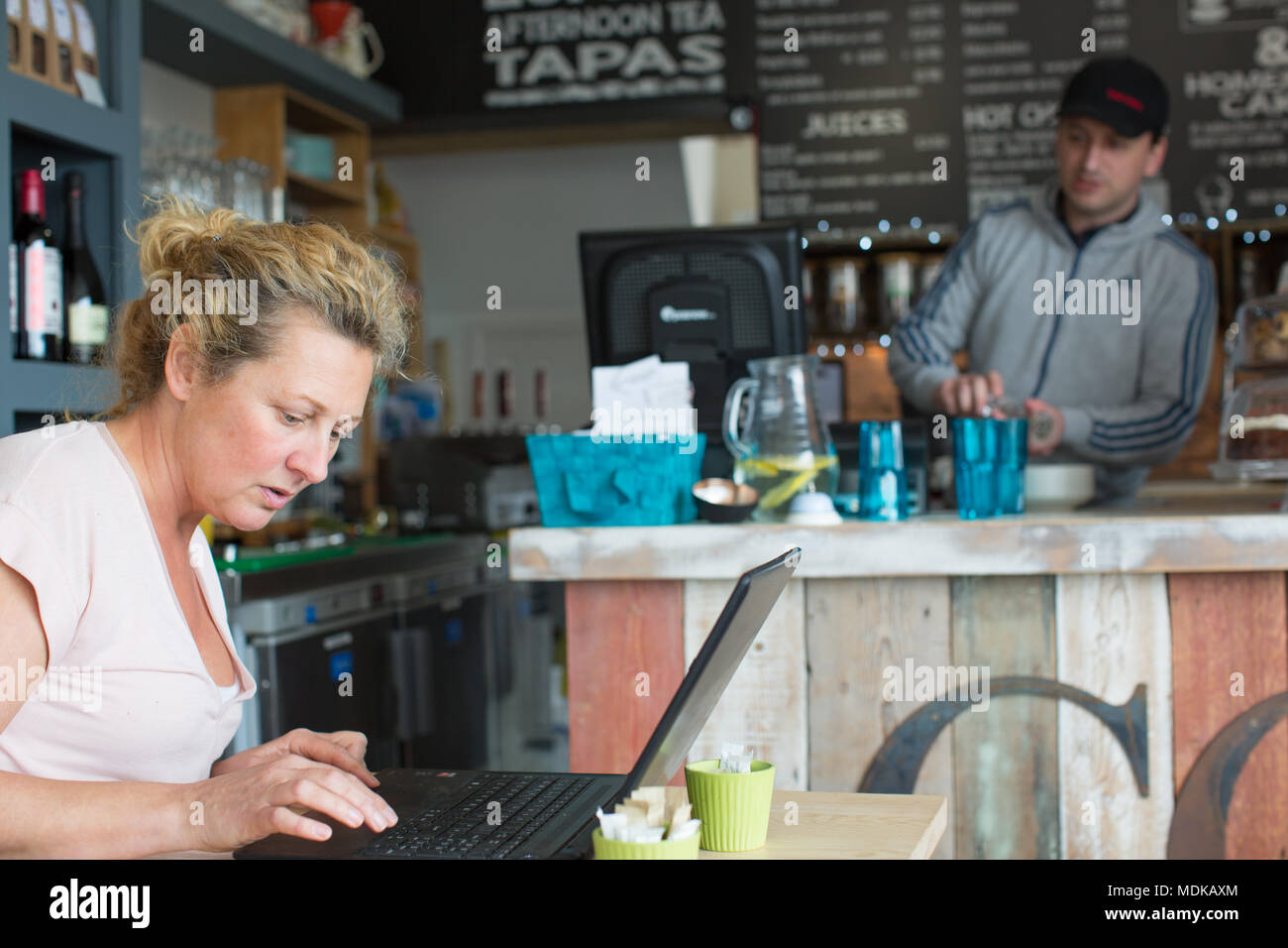 Woman working on laptop in a coffee shop Stock Photo - Alamy