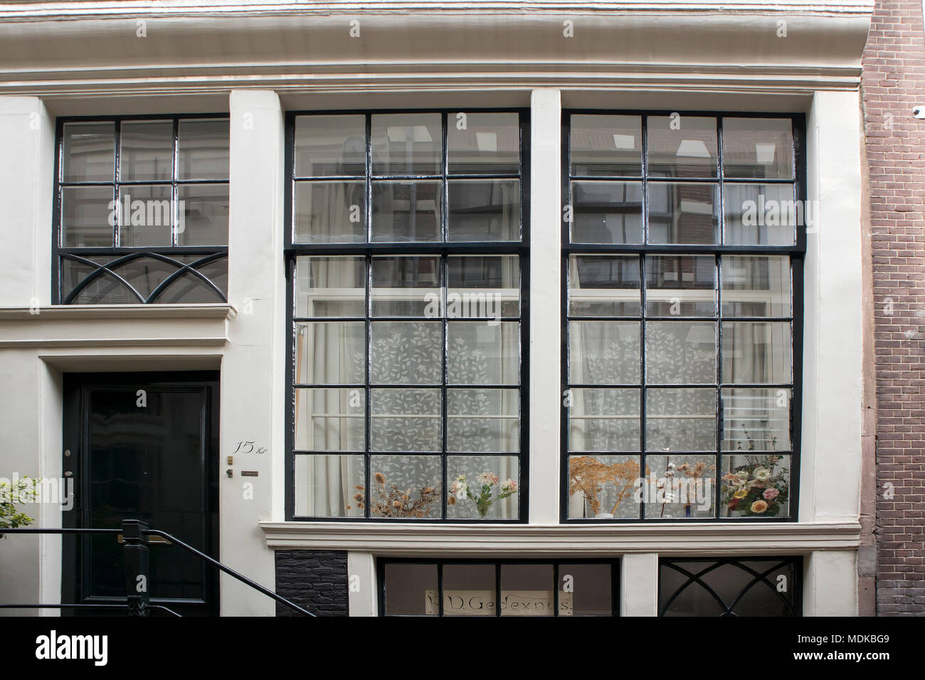 Traditional Dutch window with tulle and dry bouquets on the windowsill ...