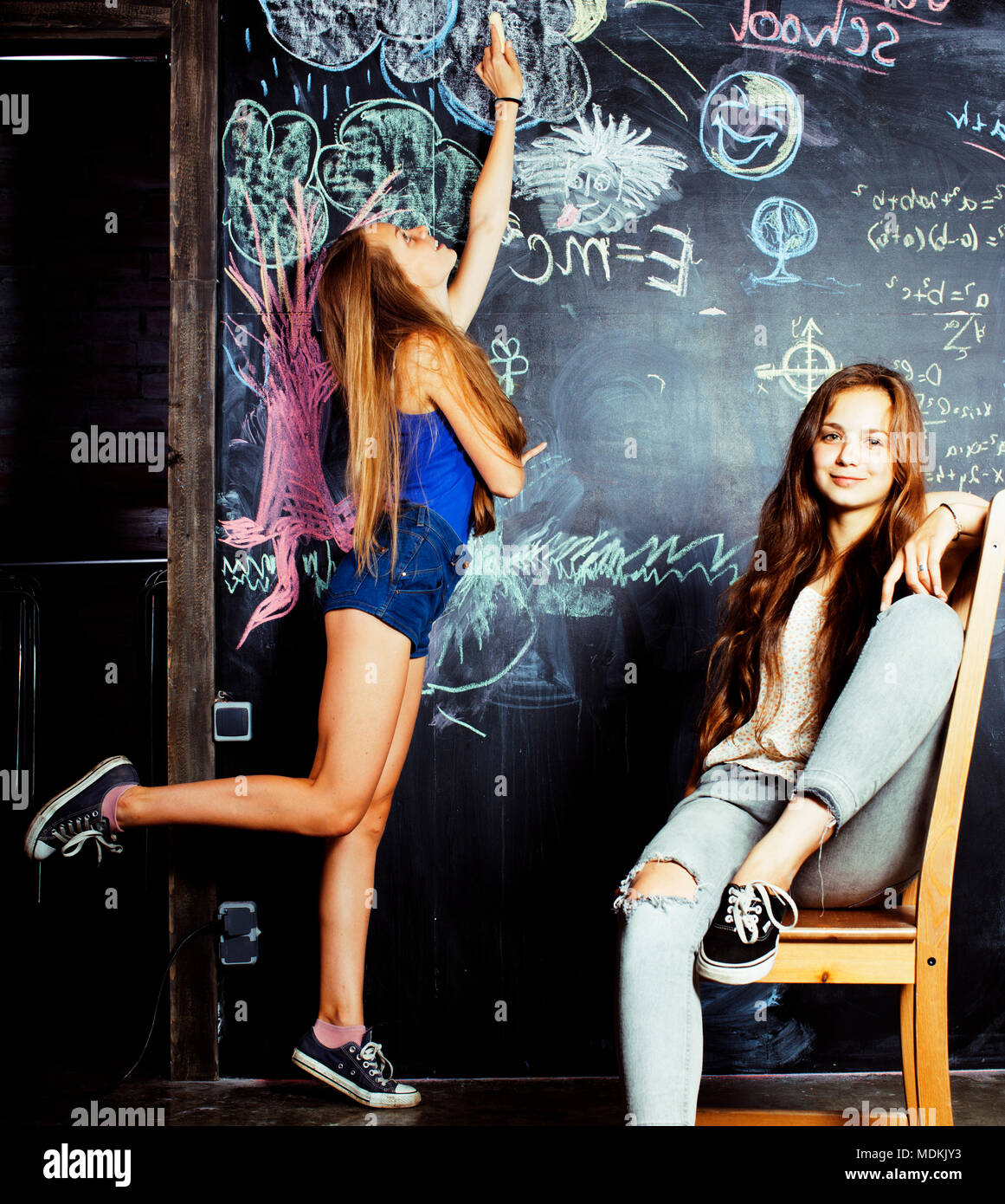 back to school after summer vacations, two teen girls in classroom with ...