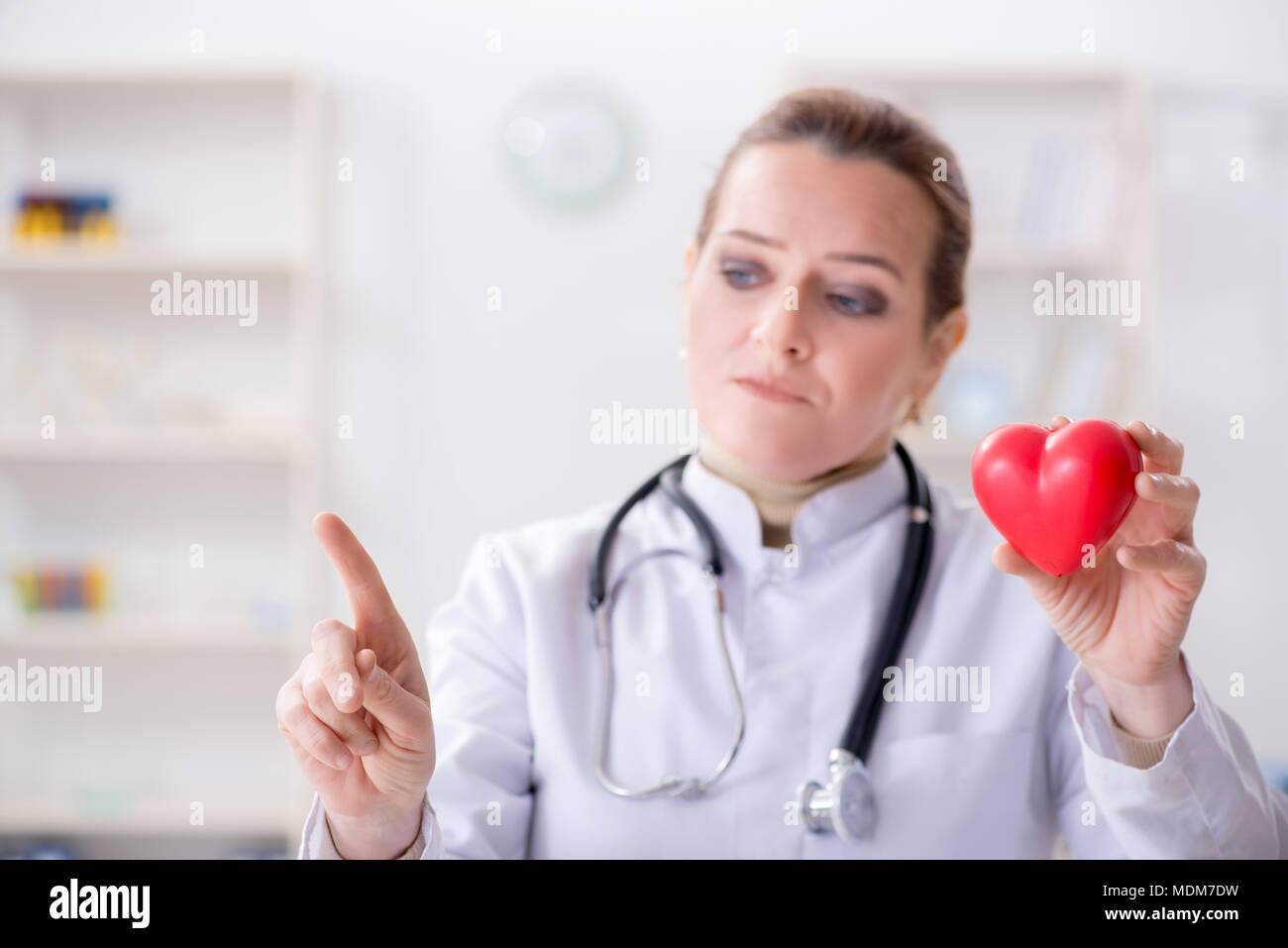 Cardiologist with red heart in medical concept Stock Photo - Alamy