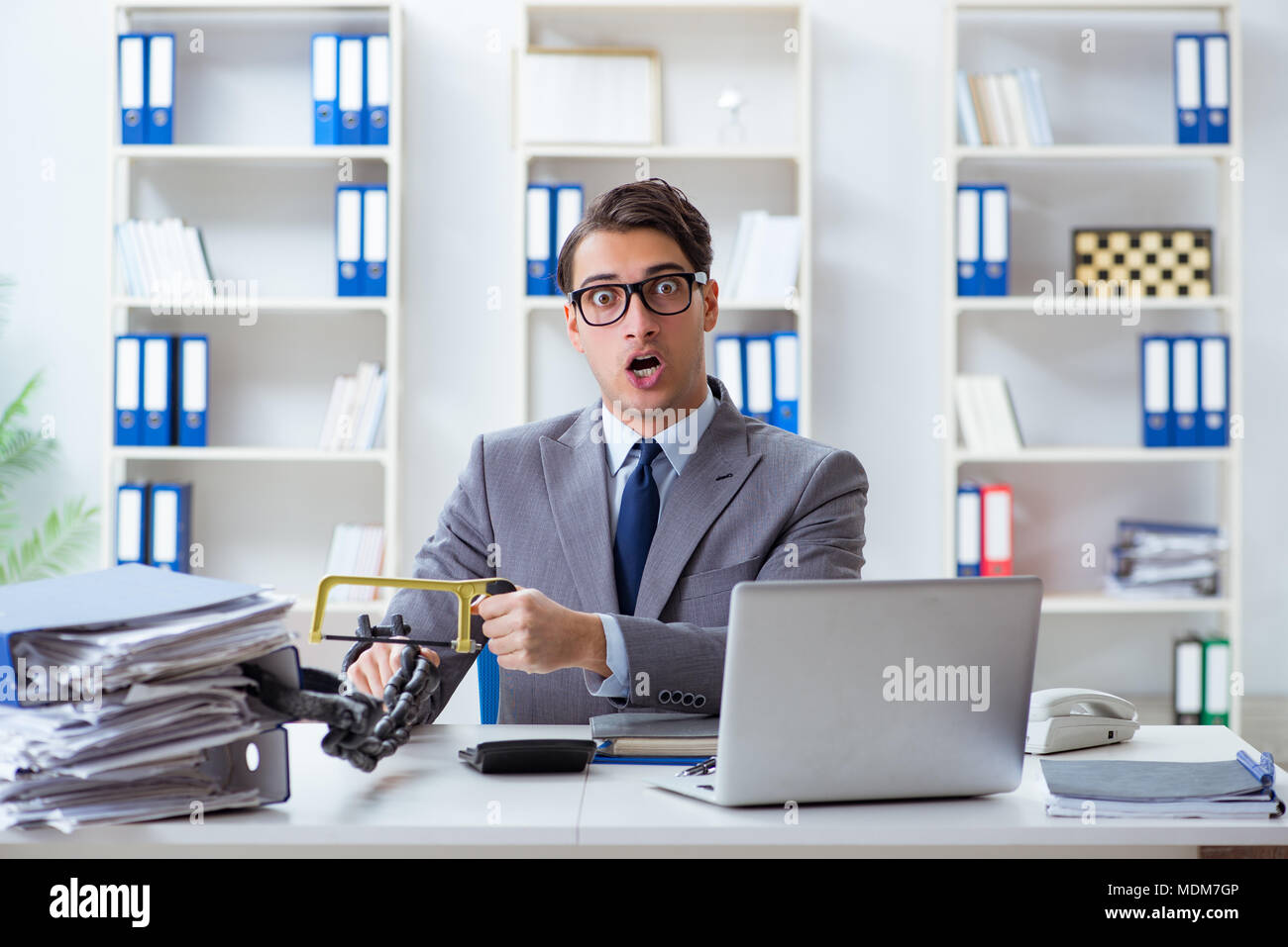 Busy employee chained to his office desk Stock Photo - Alamy