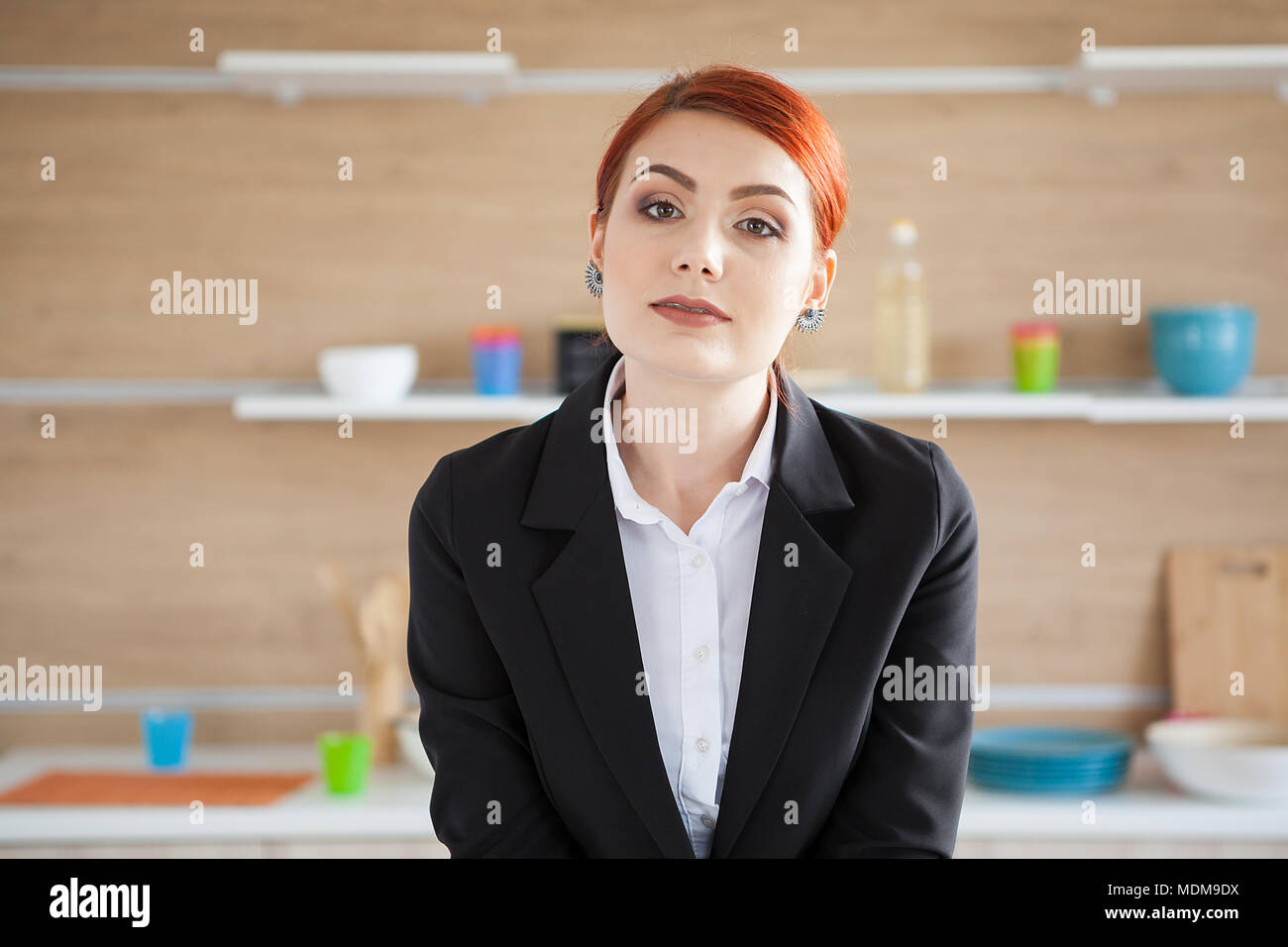 Woman in business suit posing in her kitchen Stock Photo - Alamy
