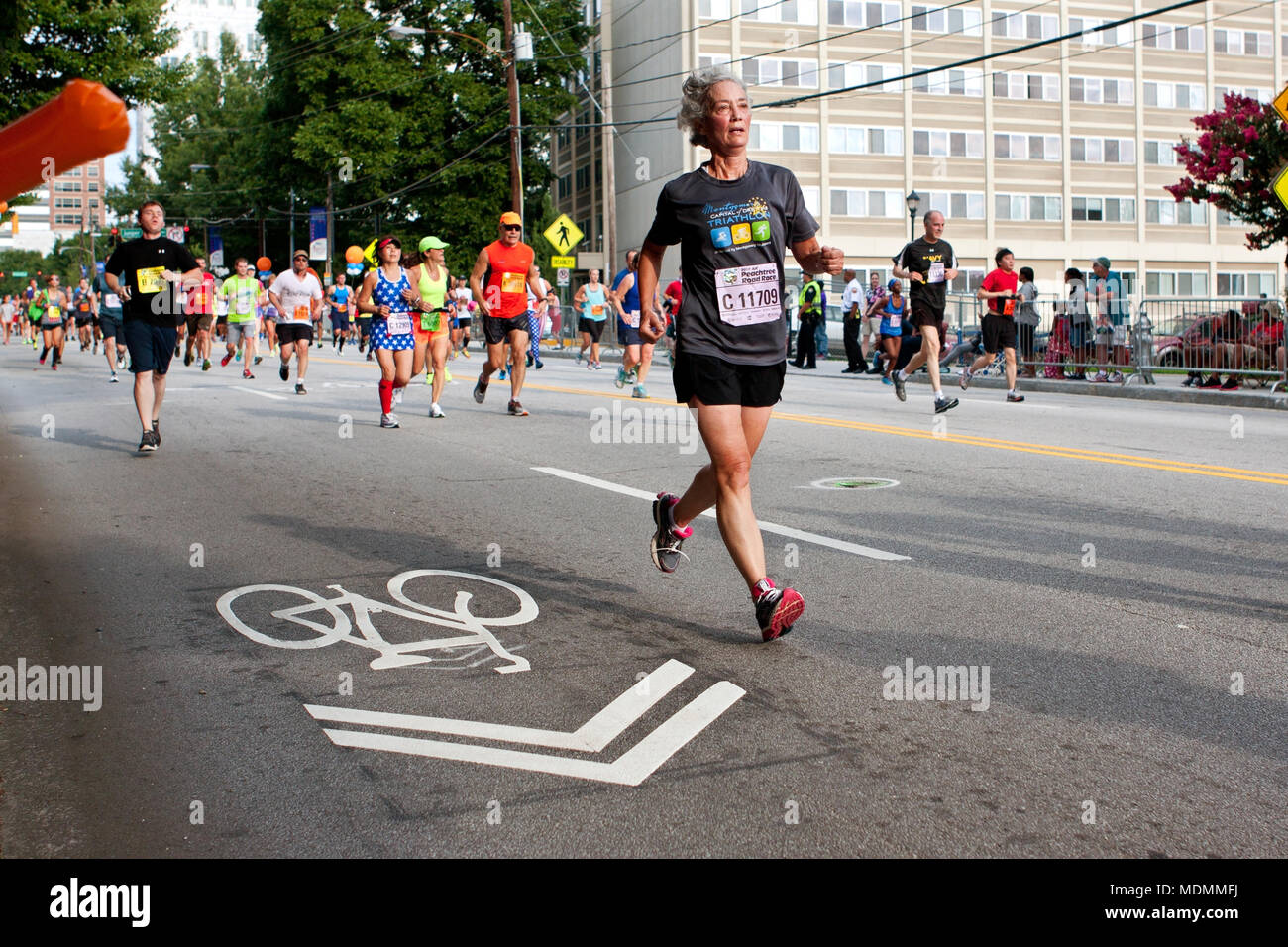 Atlanta, GA, USA - July 4, 2014: A senior woman runs toward the finish ...
