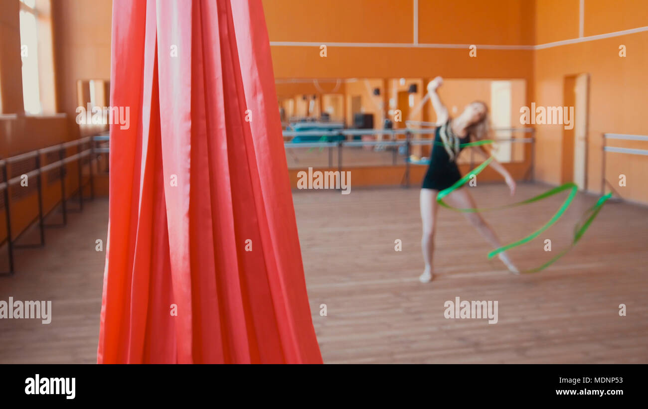 Red silk in front of young woman training a gymnastics exercise with a ...