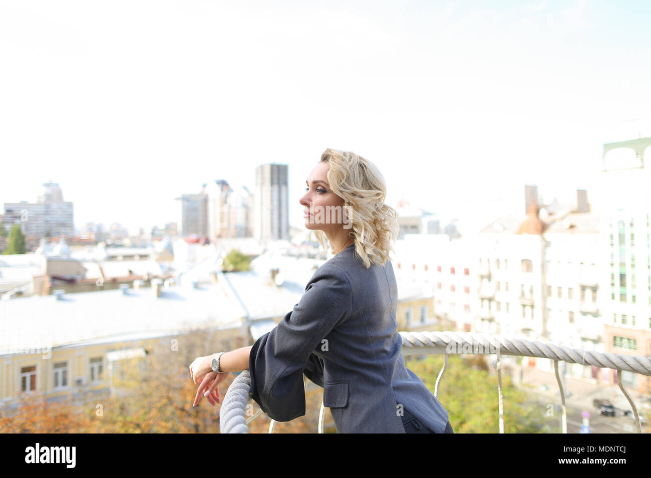 Young female person standing on balcony with cityscape background Stock ...