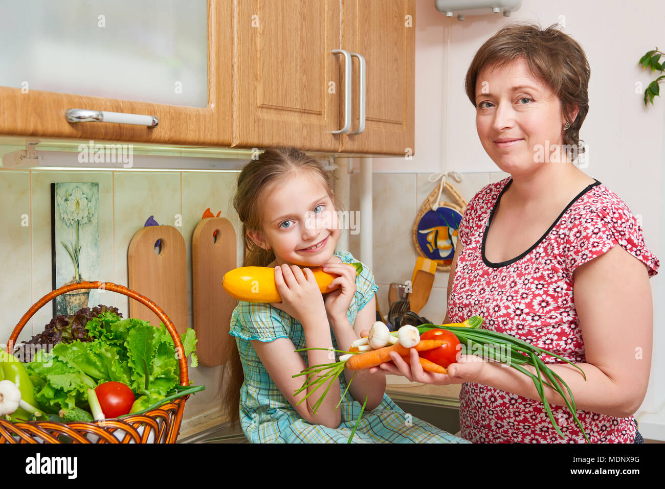 Mother and daughter with basket of vegetables and fresh fruits in ...