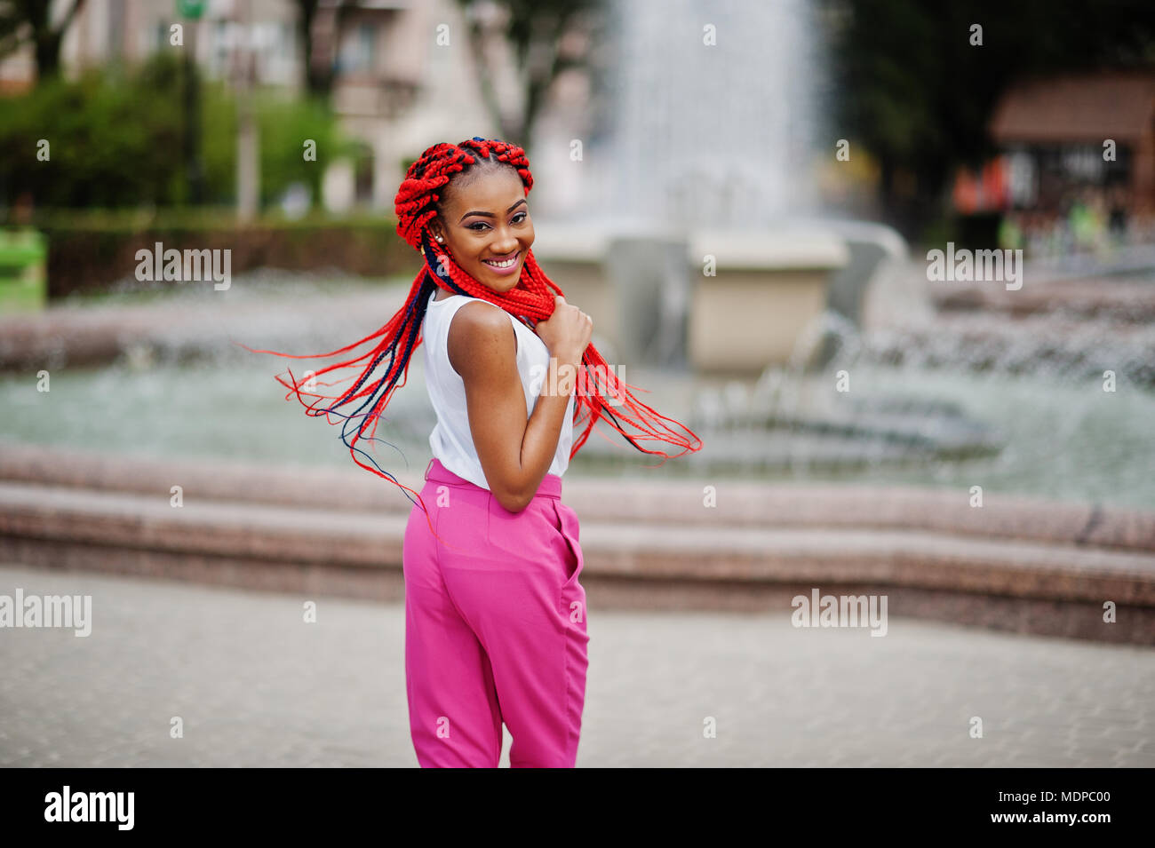 Fashionable african american girl at pink pants and red dreads posed ...