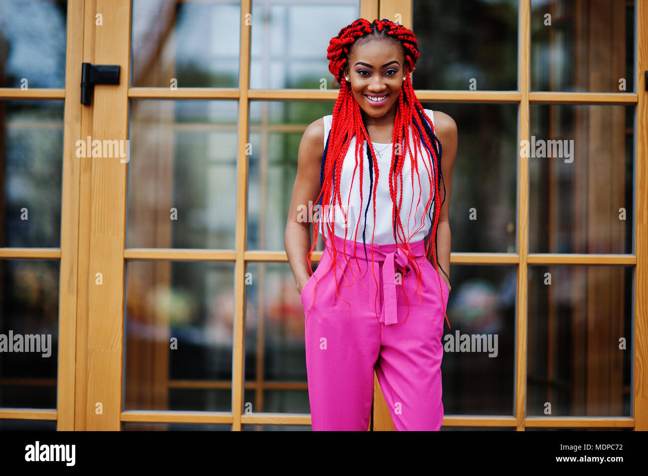 Fashionable african american girl at pink pants and red dreads posed ...