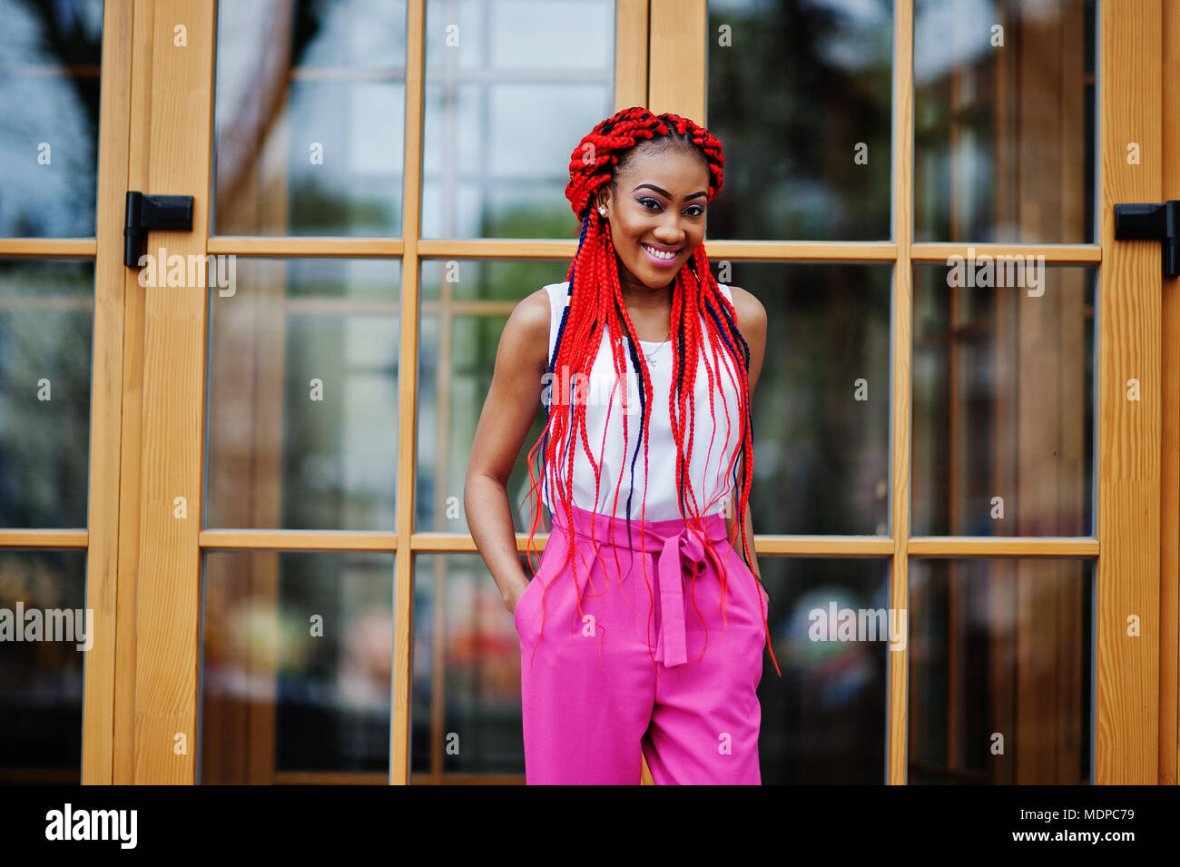 Fashionable african american girl at pink pants and red dreads posed ...