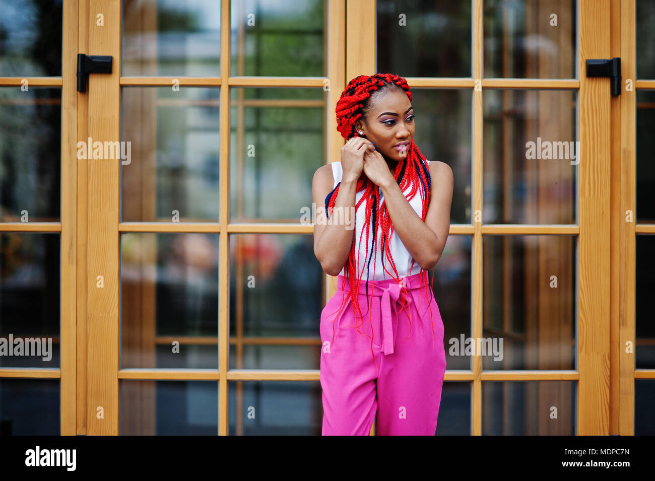 Fashionable african american girl at pink pants and red dreads posed ...