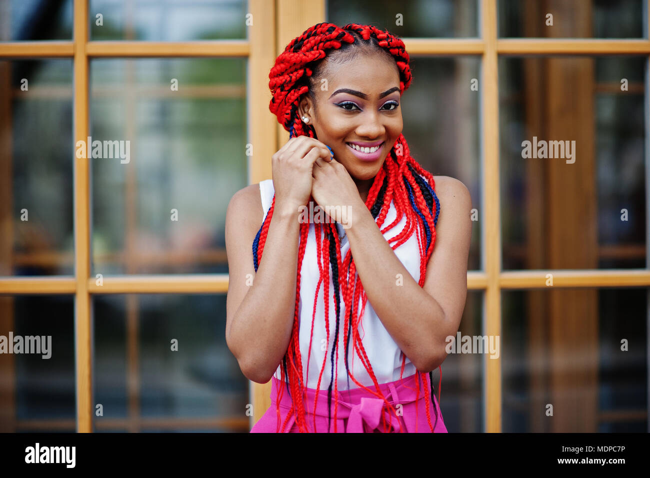 Fashionable african american girl at pink pants and red dreads posed ...