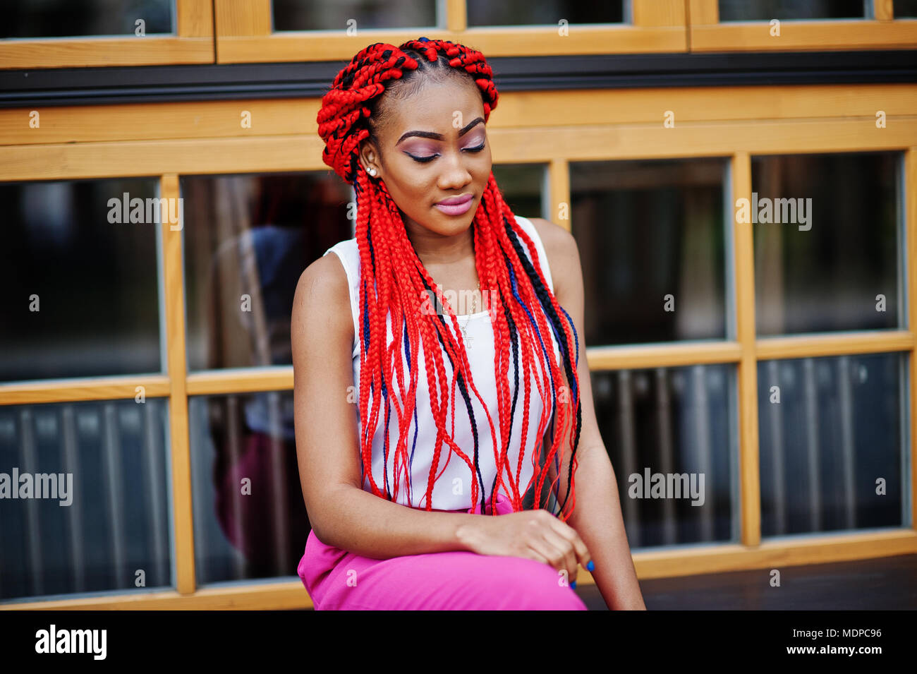 Fashionable african american girl at pink pants and red dreads posed ...