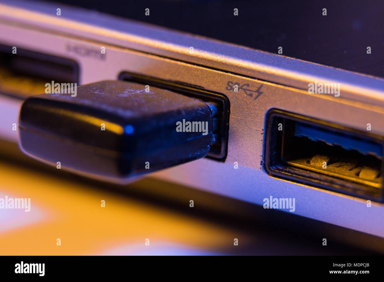 Closeup of USB flash drive inserted into port on the side of a laptop ...