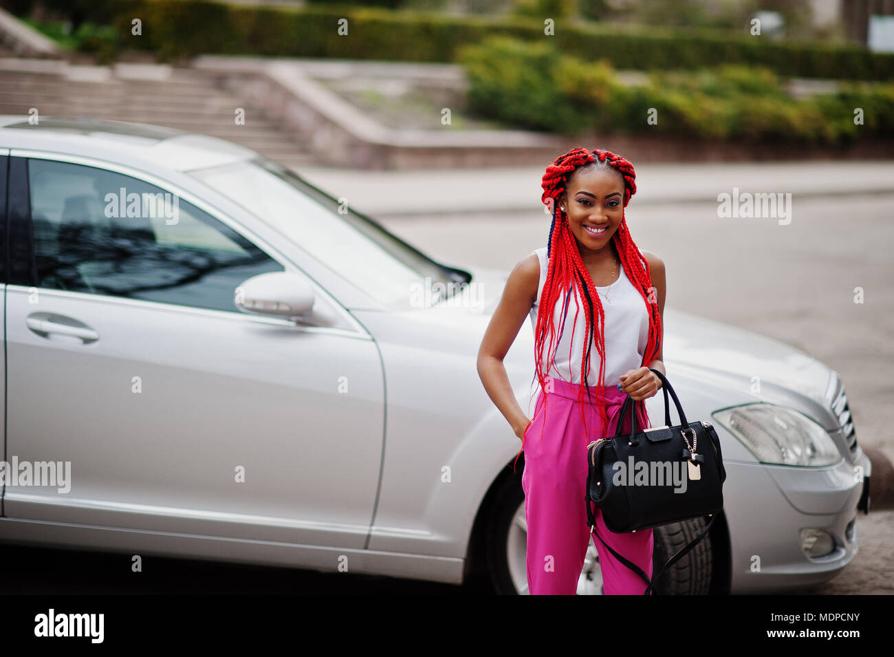 Fashionable african american business woman at pink pants and red ...