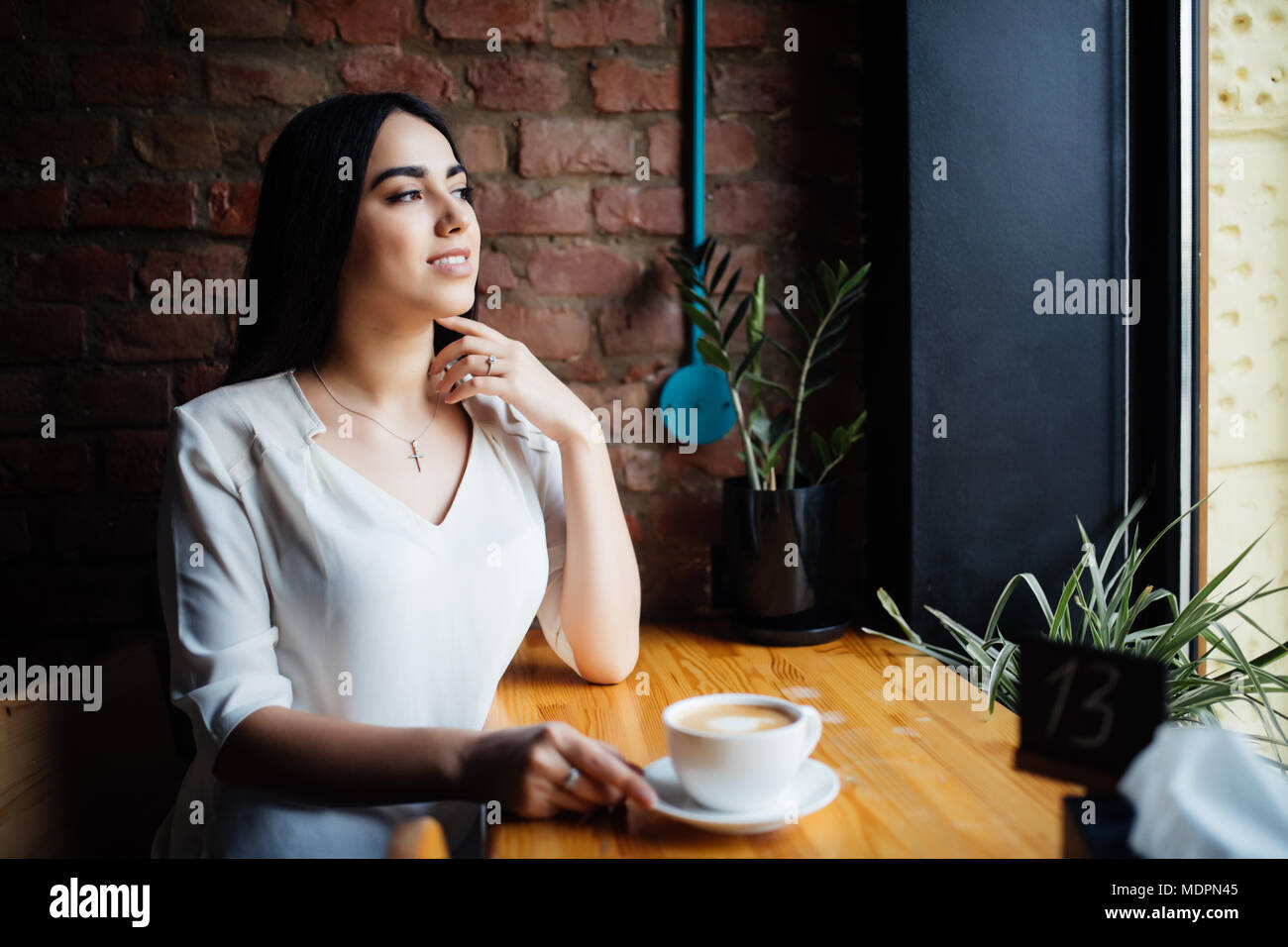 Young woman drinking coffee in a cafe outdoors Stock Photo - Alamy