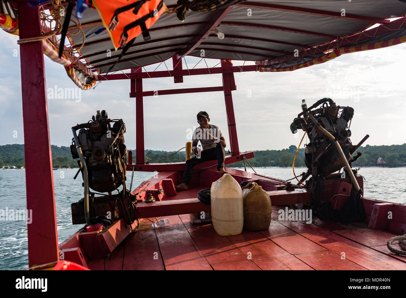 A close-up of a motor engine on a Cambodian longtail boat with captain ...