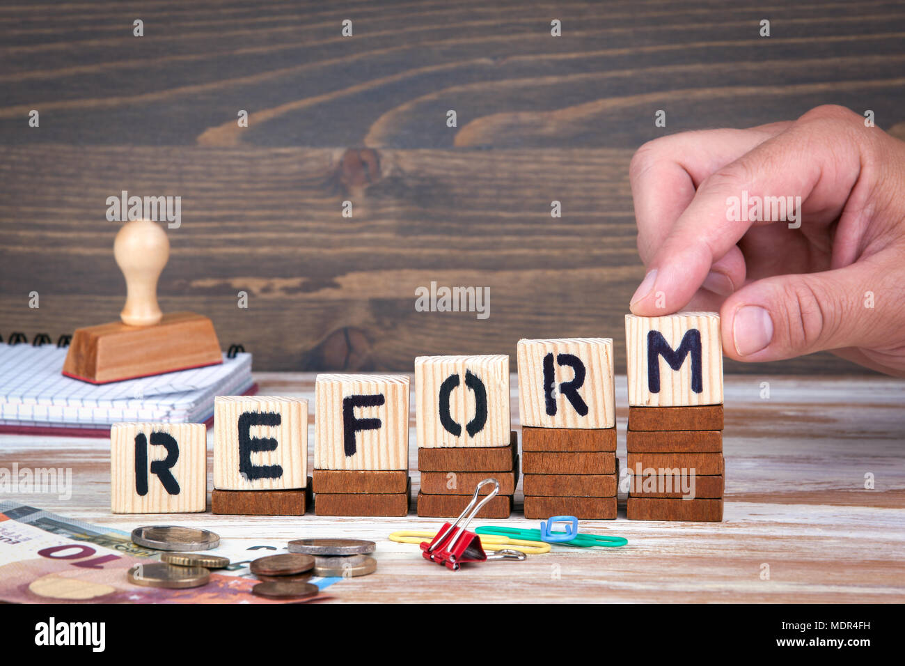 Reform concept. Wooden letters on the office desk, informative and ...